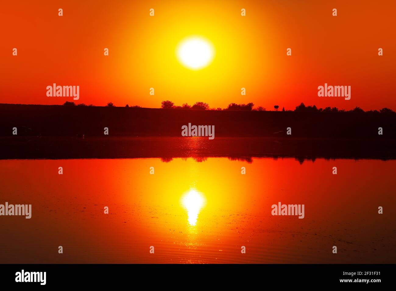 Sunset and red sky reflection in the lake water Stock Photo - Alamy