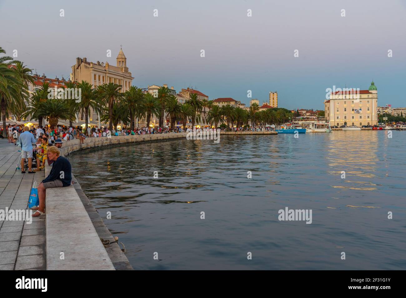 Split, Croatia, July 29, 2020: Night view of people walking on seaside ...