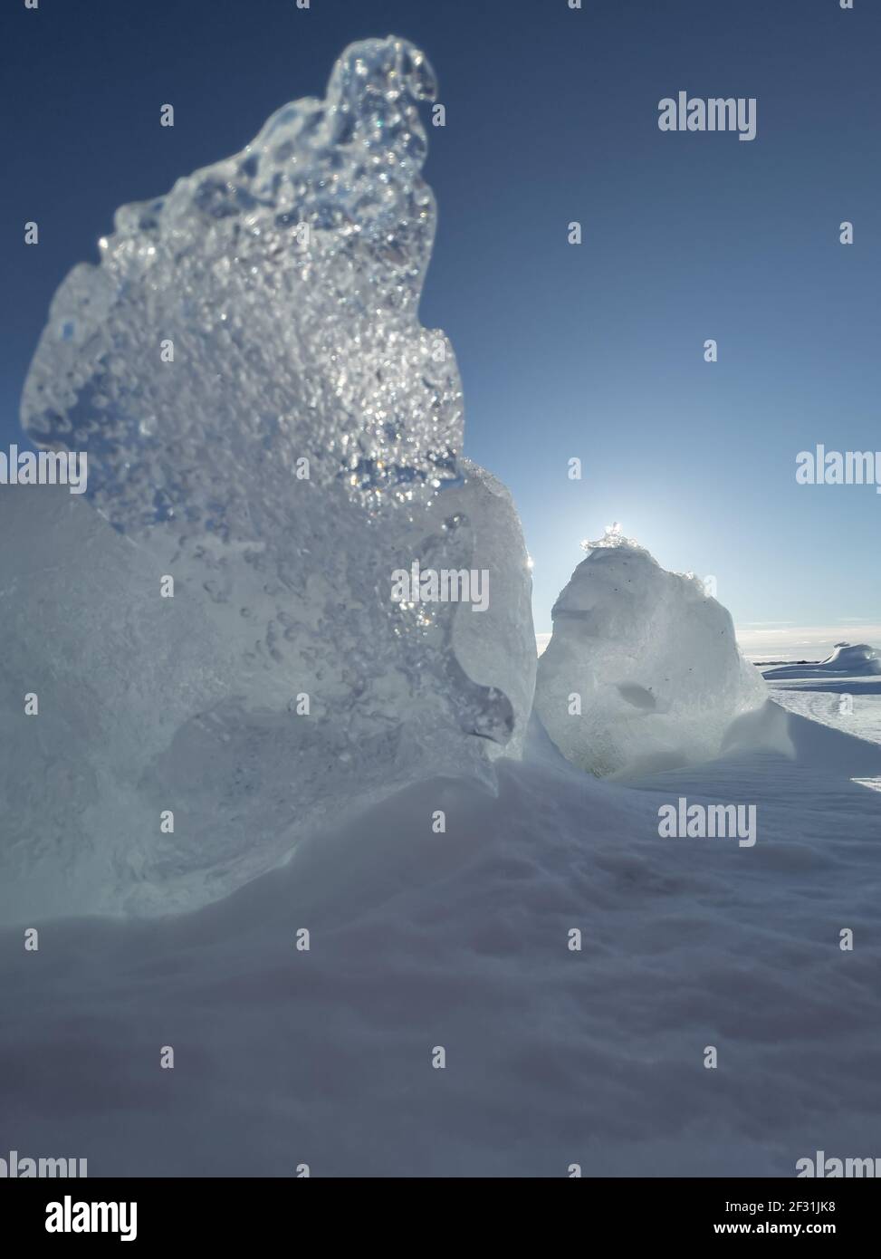 Ice slopes in sunny winter day, transparent ice of blue color, purely ...