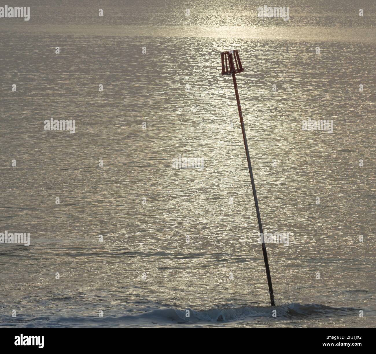 Tall post stands out as a marker on a beach in the south of England ...