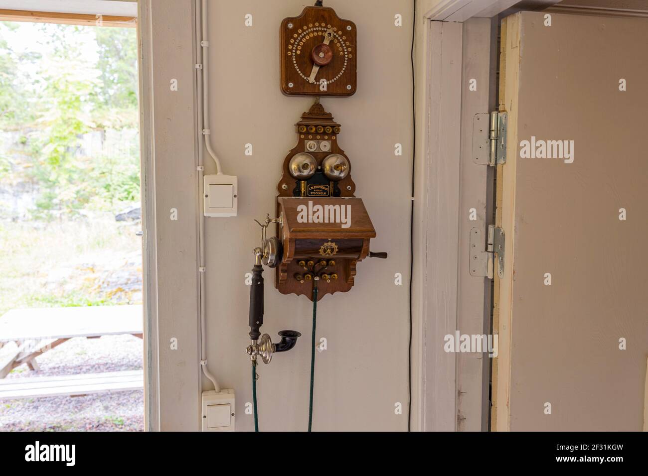 Close up view of vintage retro phone and wall clock on white wall ...