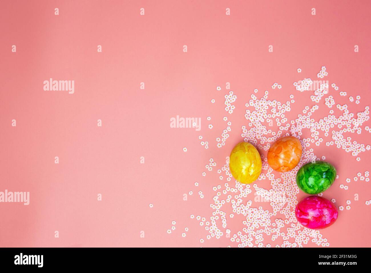 Colorful painted Easter eggs on pastel pink background with pink ...