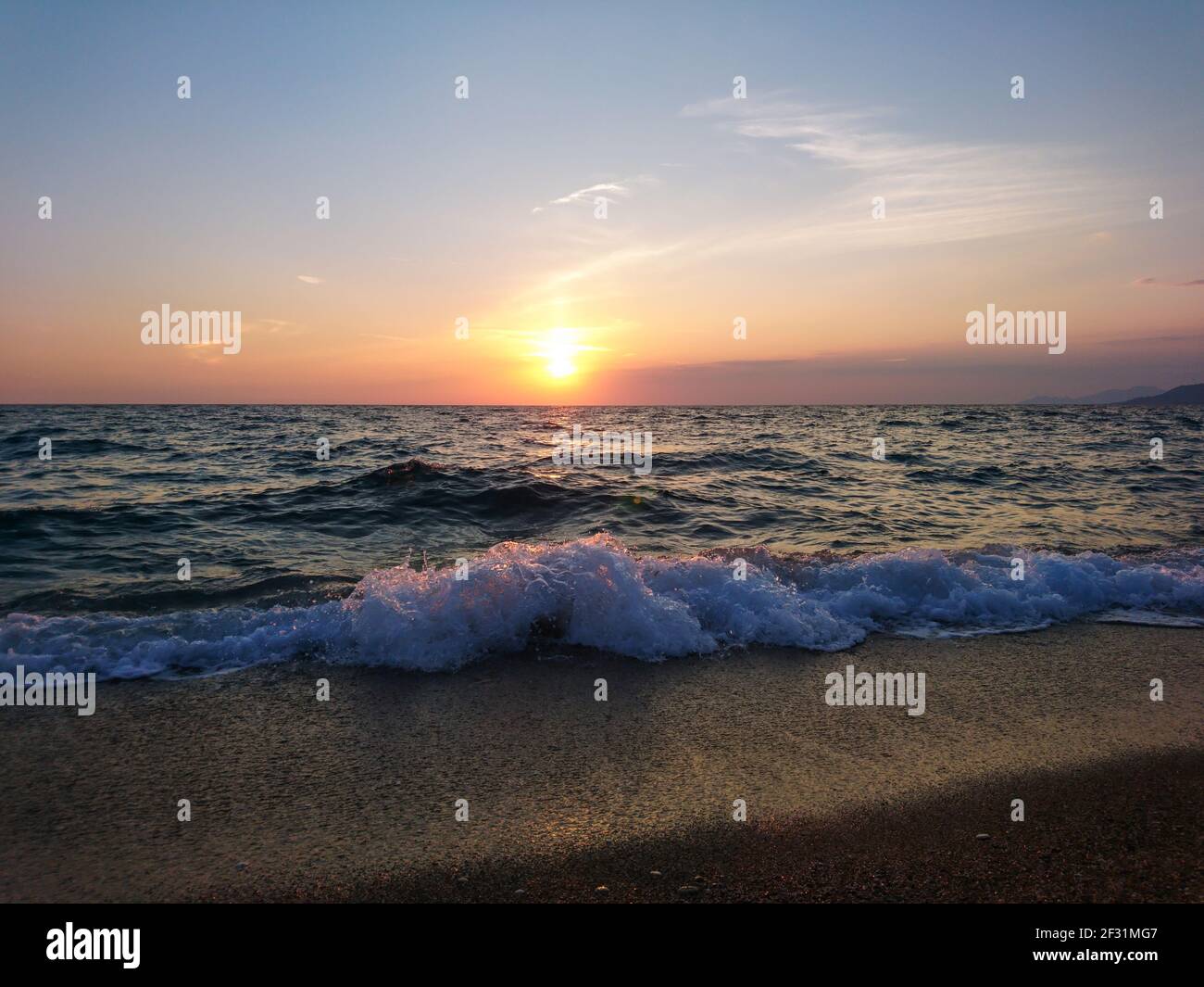 Orange sunset sun shining on sea shore with beautiful white waves ...