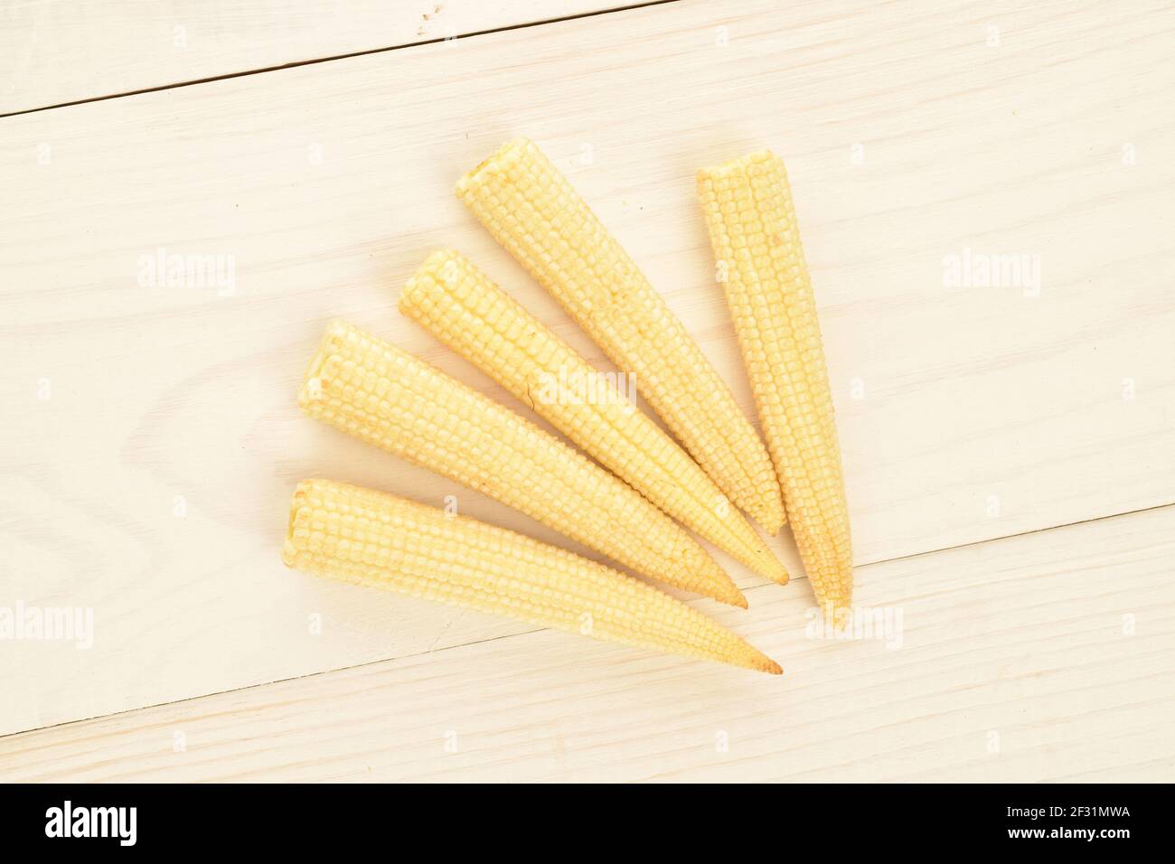 Several bright yellow ripe sweet organic mini corn, close-up, on a ...