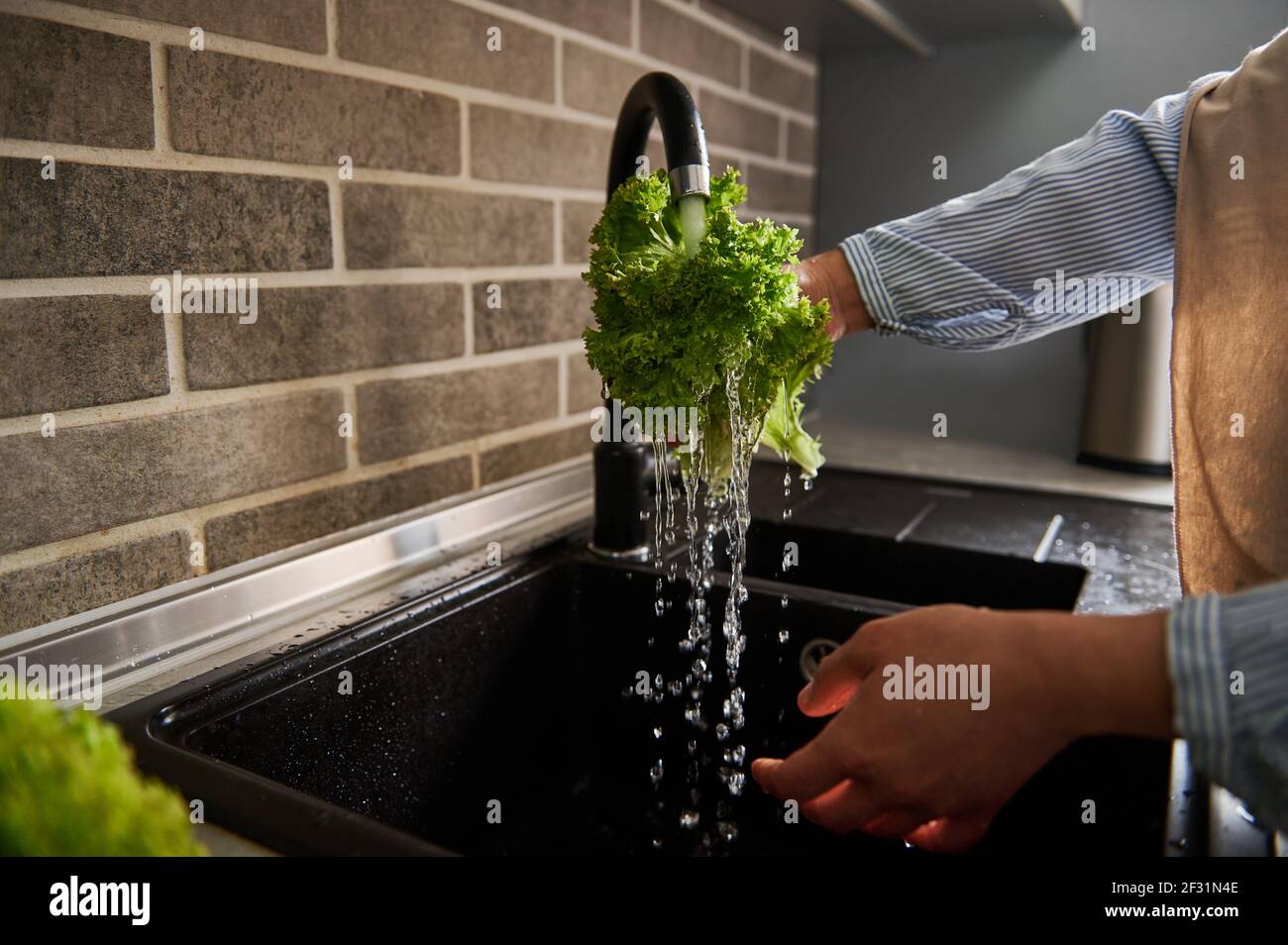 Closeup of washing salad leaves. Water drops drip from washed lettuce ...