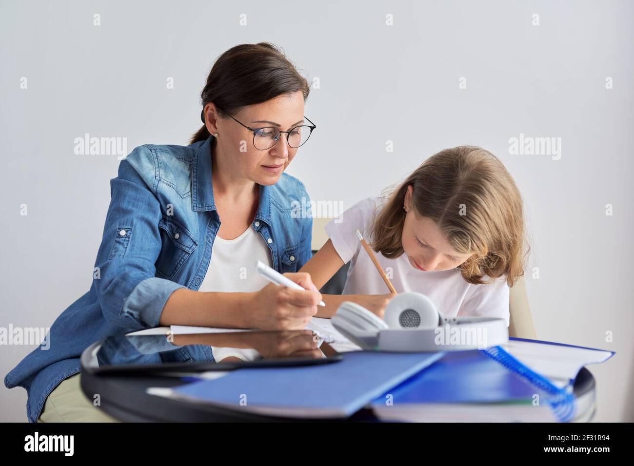 Mom and daughter student learning school lessons together at home Stock ...