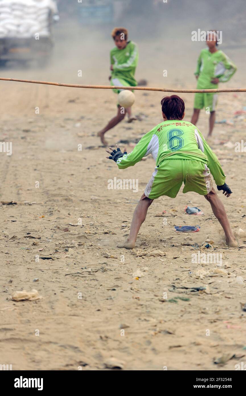 Children playing soccer on the Ayeyarwady River banks in Myanmar Burma ...