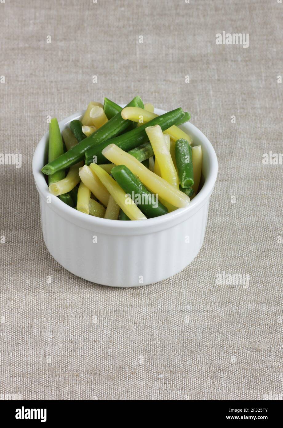 Frozen legume vegetables - green bean - in bowl on linen background ...