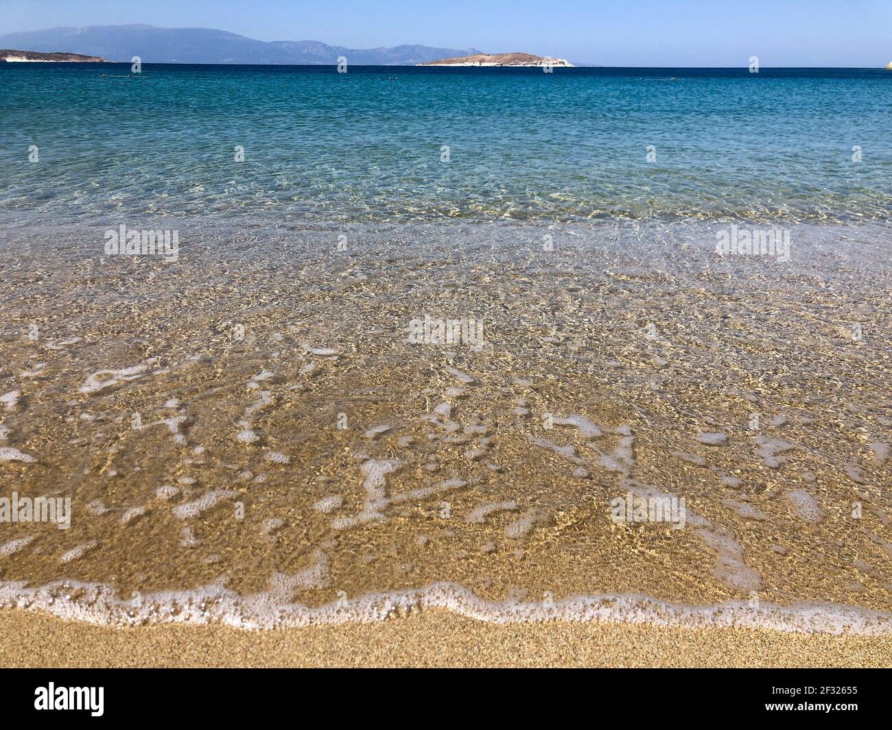 smooth waves of a calm sea on a sandy beach in summer Stock Photo - Alamy