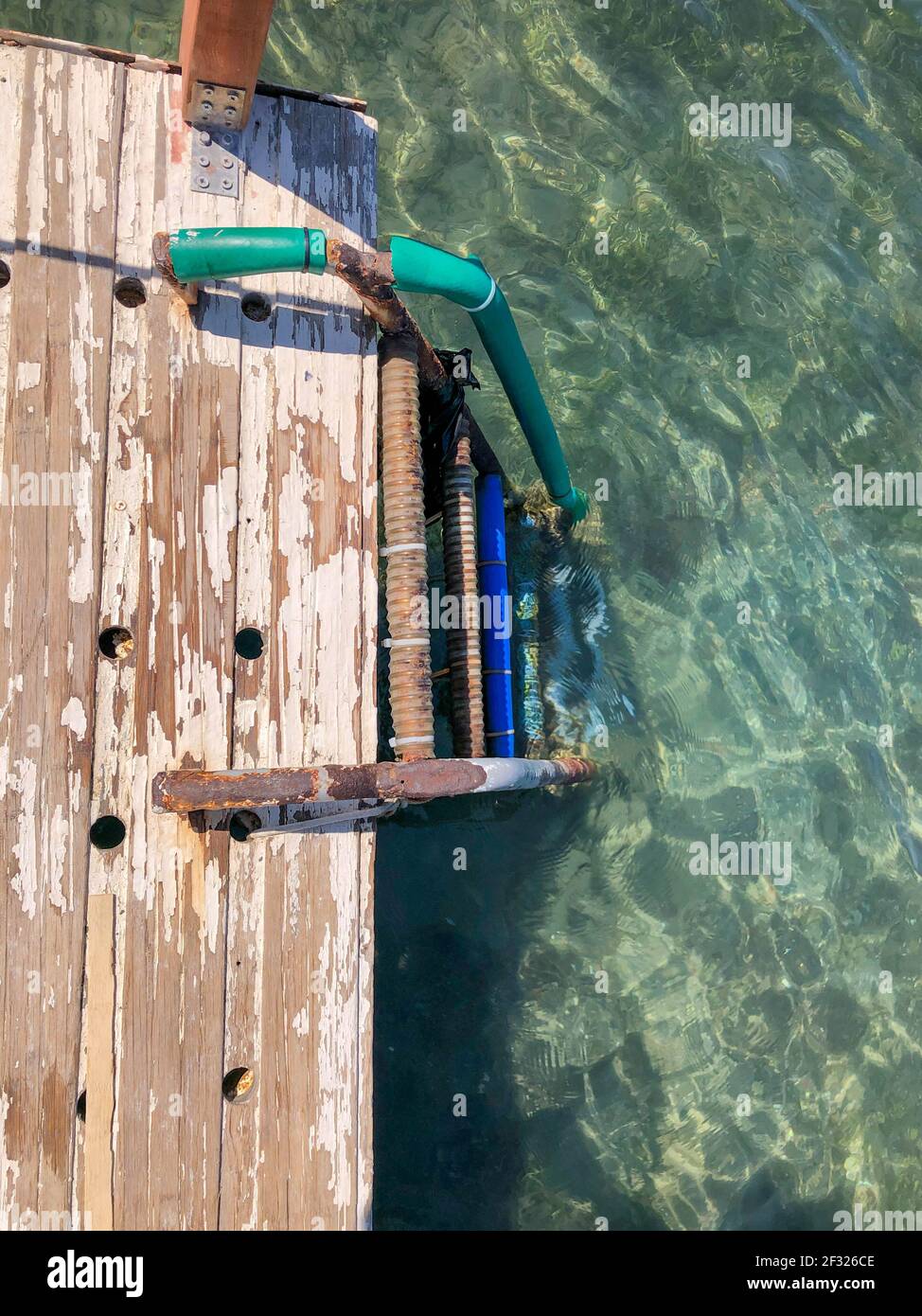 old and rusty ladder descending from the wooden pier to the sea Stock ...