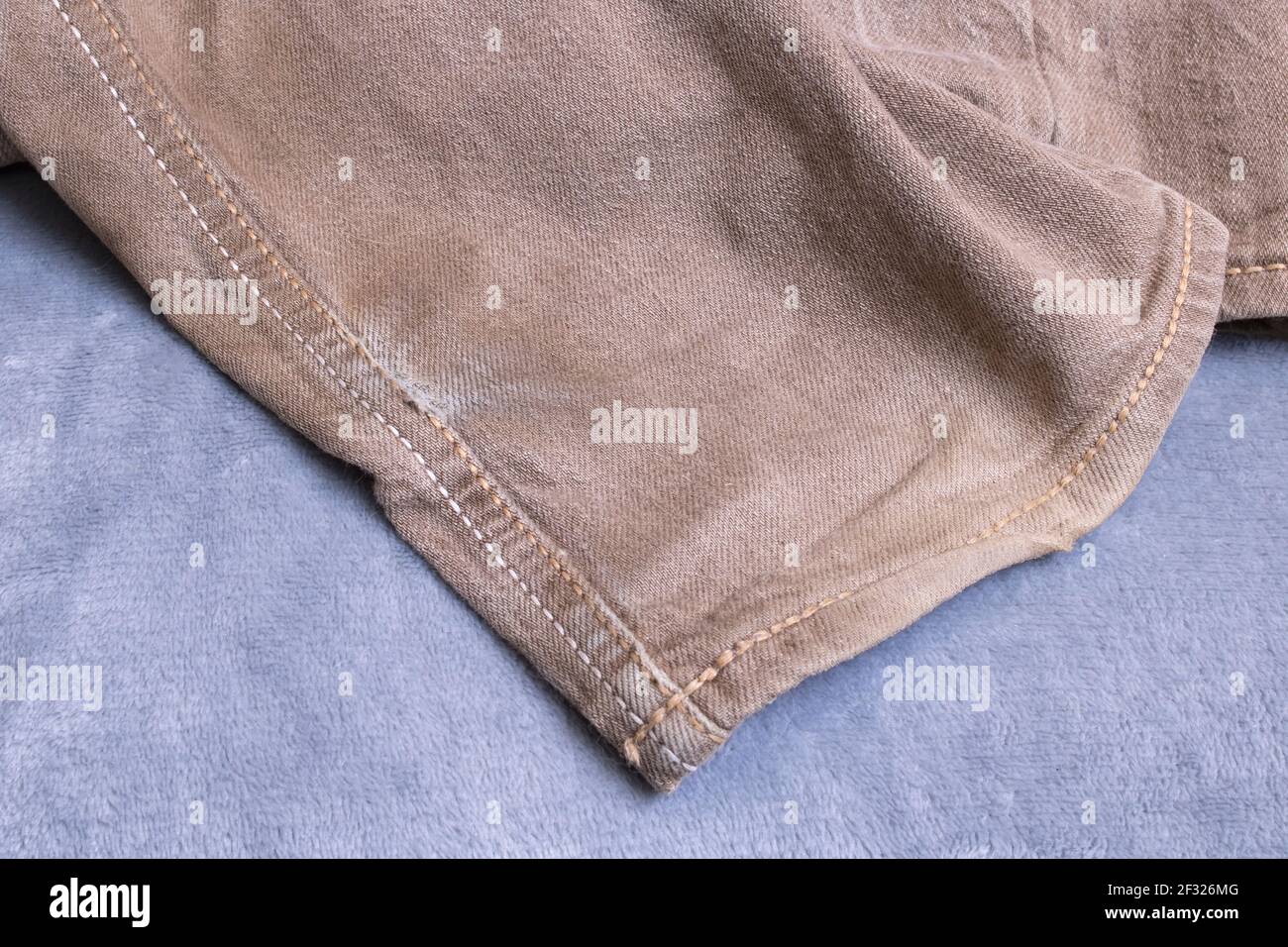 Old worn denim on a gray background close up Stock Photo - Alamy