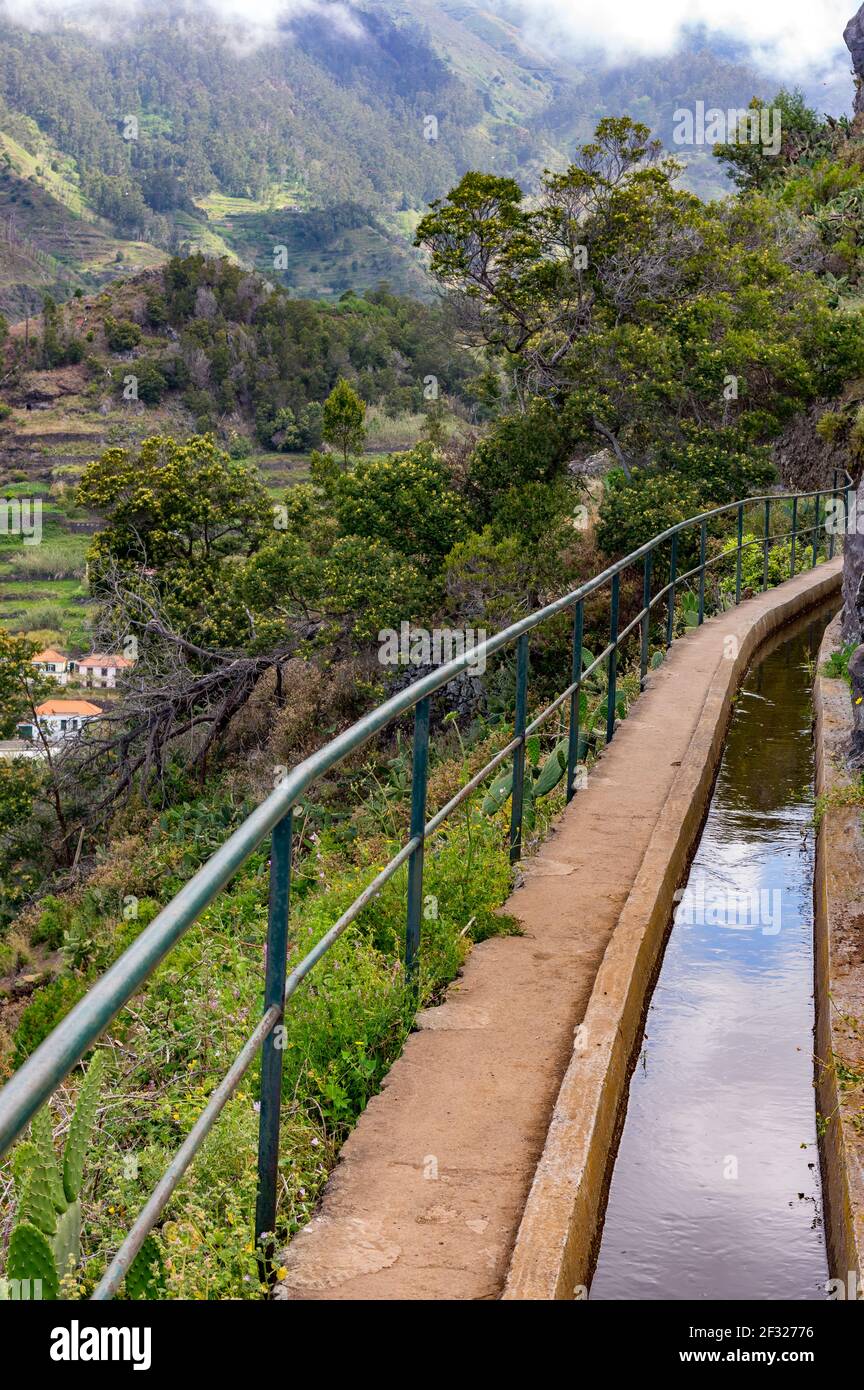 Levada hiking trail secured with a railing in the mountains of Madeira ...