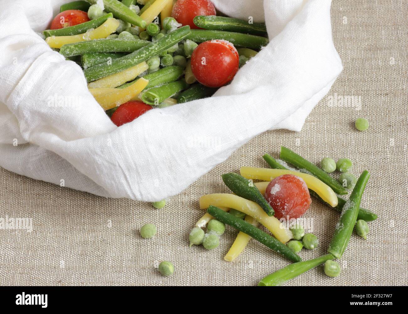 Frozen vegetables in plastic free zero waste cloth bag on linen fabric ...