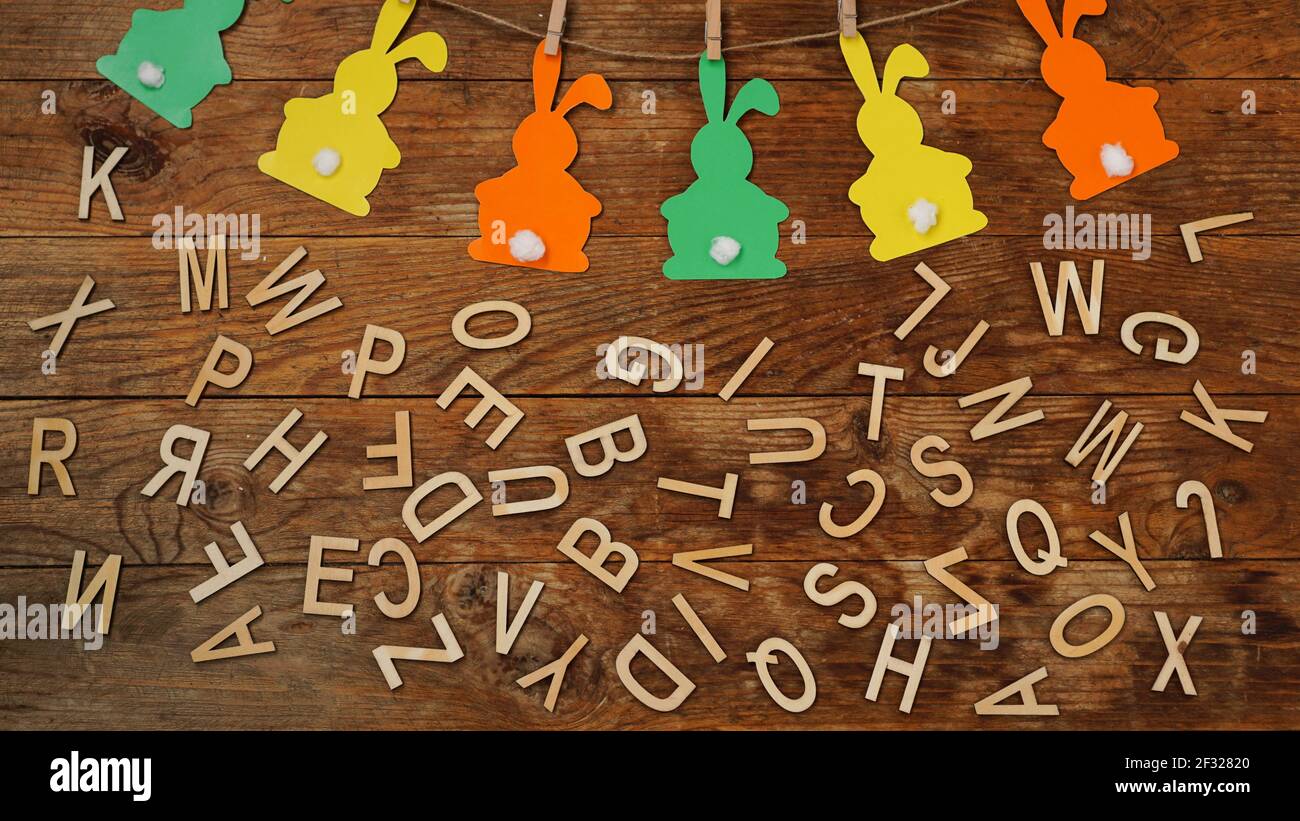 Easter background. Garland of paper rabbits and letters on wooden ...
