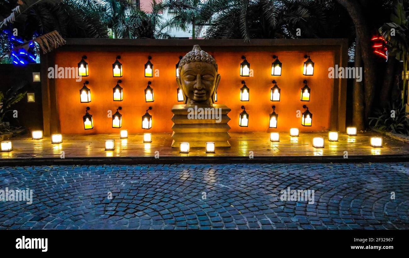 the statue of a Buddha on the background of illuminated lights in the ...