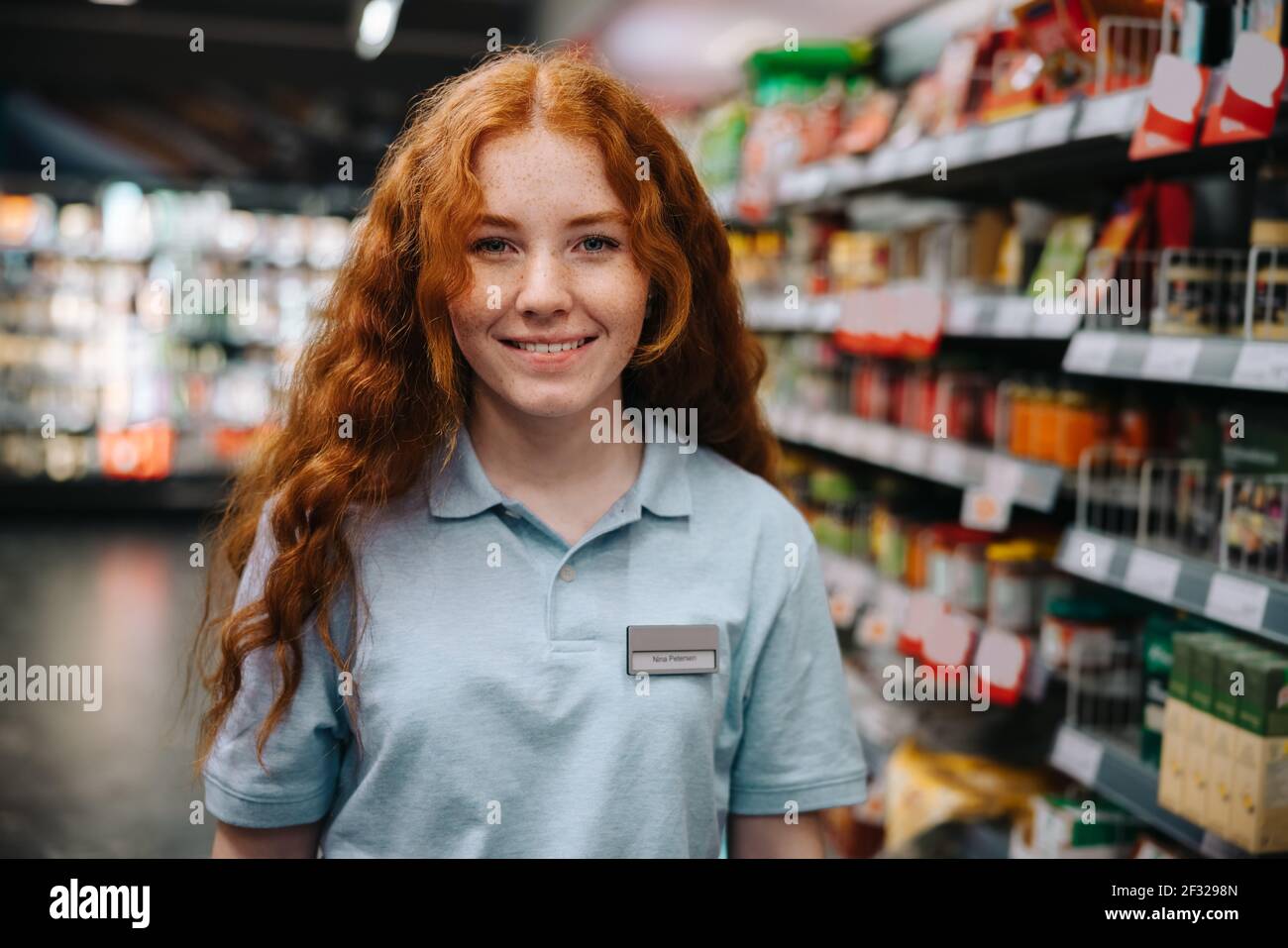 Portrait of a young woman working at supermarket during holidays. Woman ...