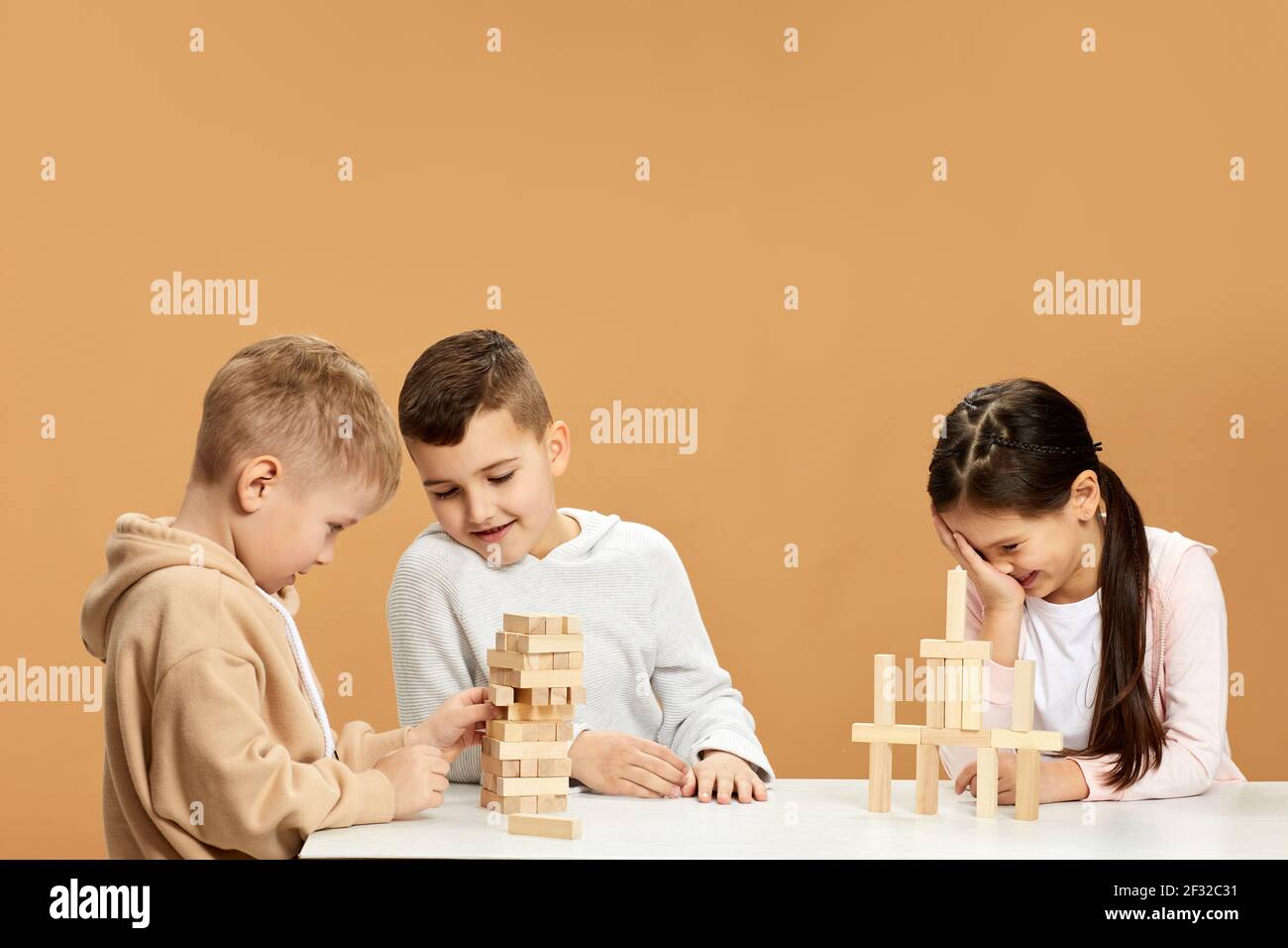 children plays with wooden constructor on desk Stock Photo - Alamy