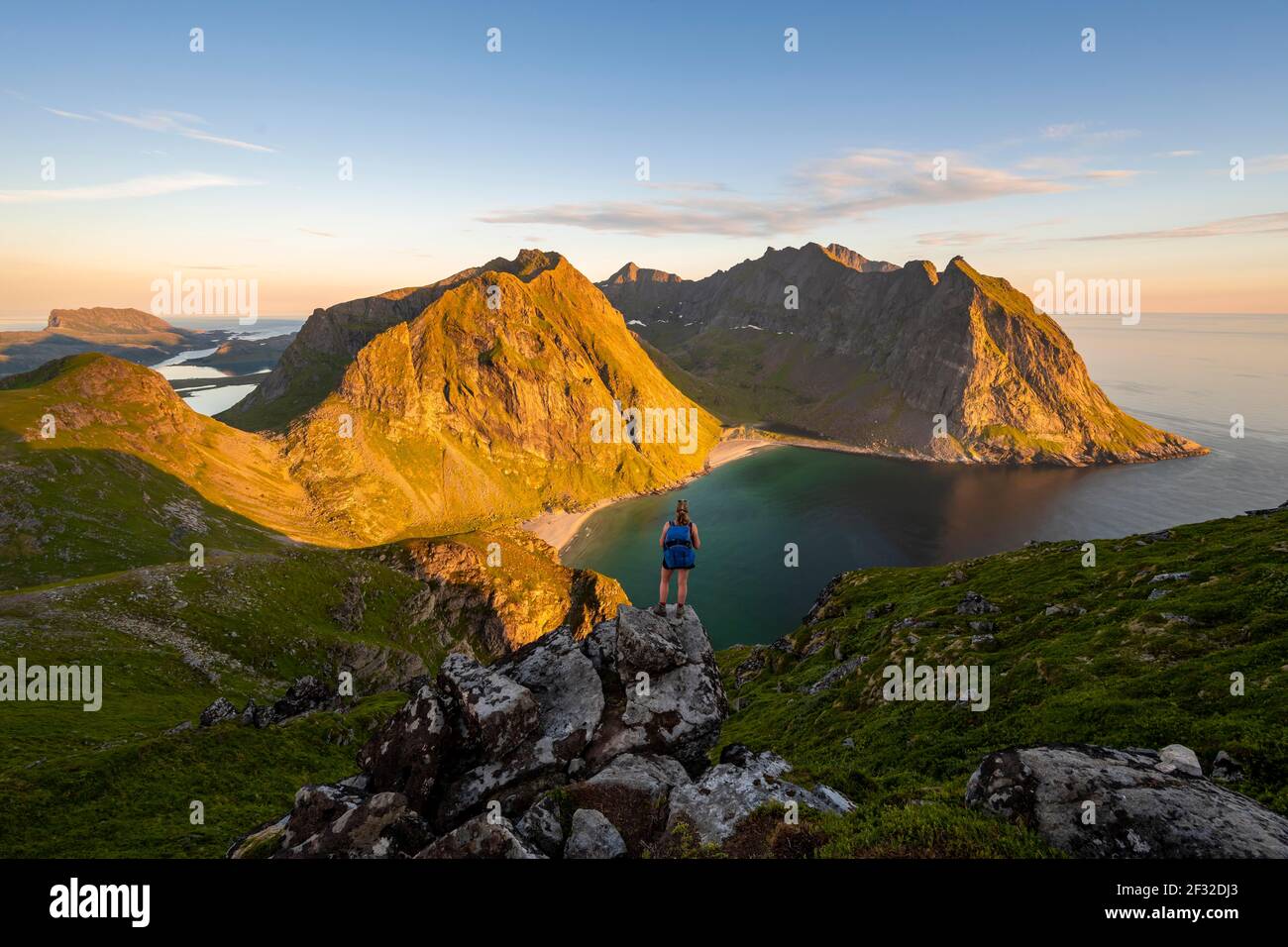Evening atmosphere, hiker on top of Ryten, sea, Kvalvika beach and ...