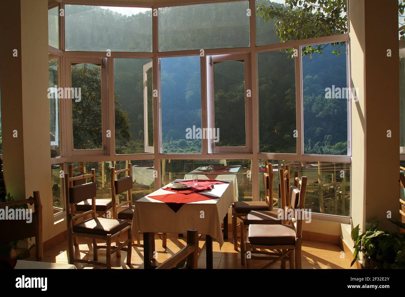 A dining table of the restaurant with a window view on the nature ...