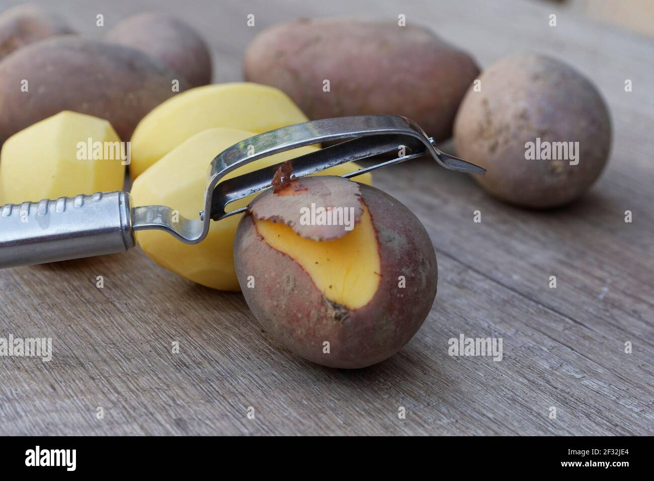 Potato peeler with potatos Laura Stock Photo - Alamy