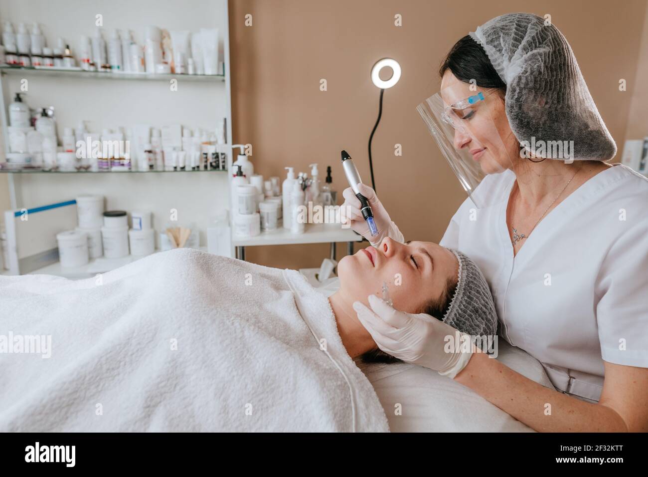 Close-up of an esthetician making facial cleansing procedure in a ...