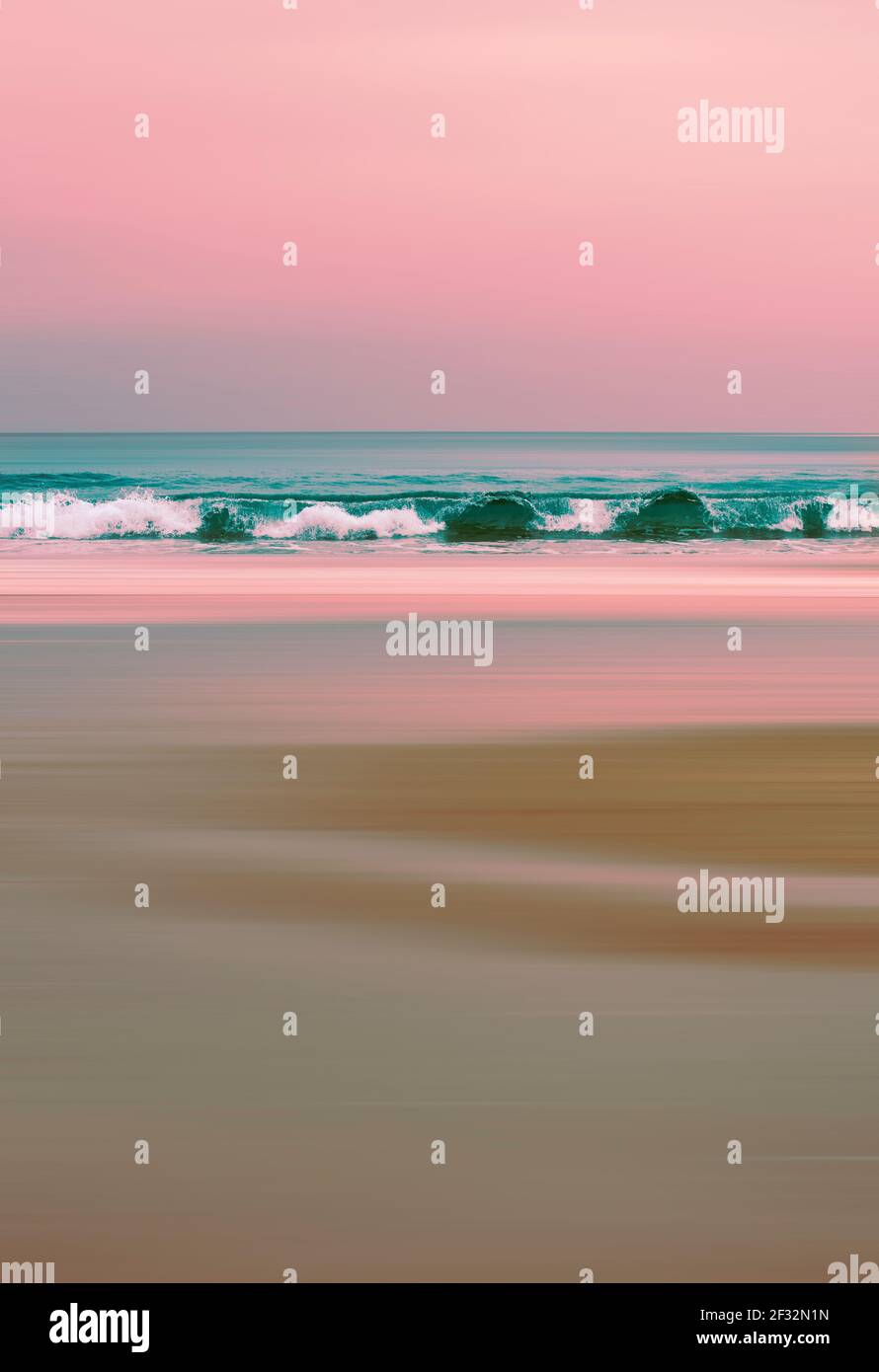 A view of turquoise ocean with breaking waves on a beautiful pink ...