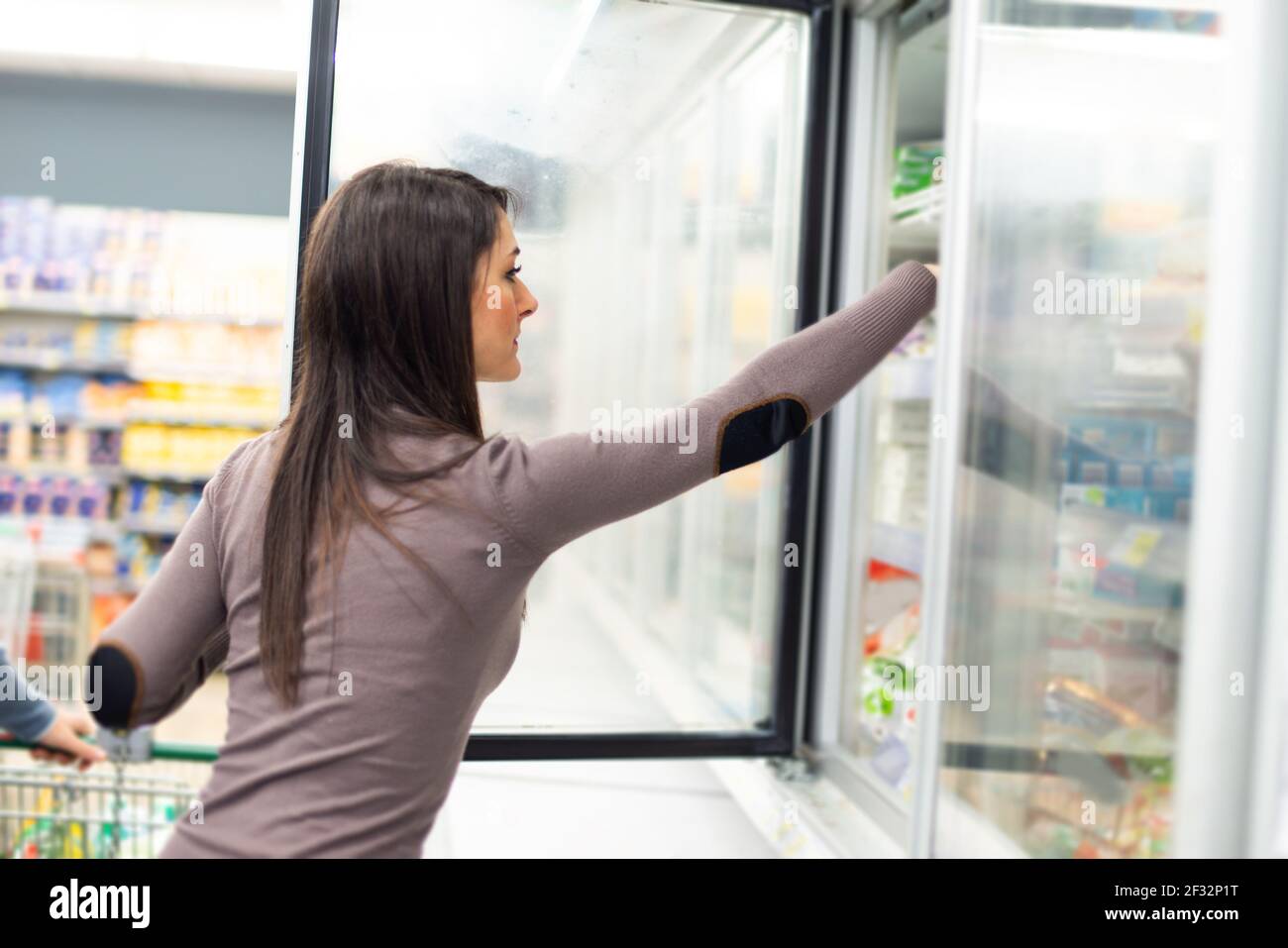 Woman taking deep frozen food from a freezer in a spuermarket Stock ...