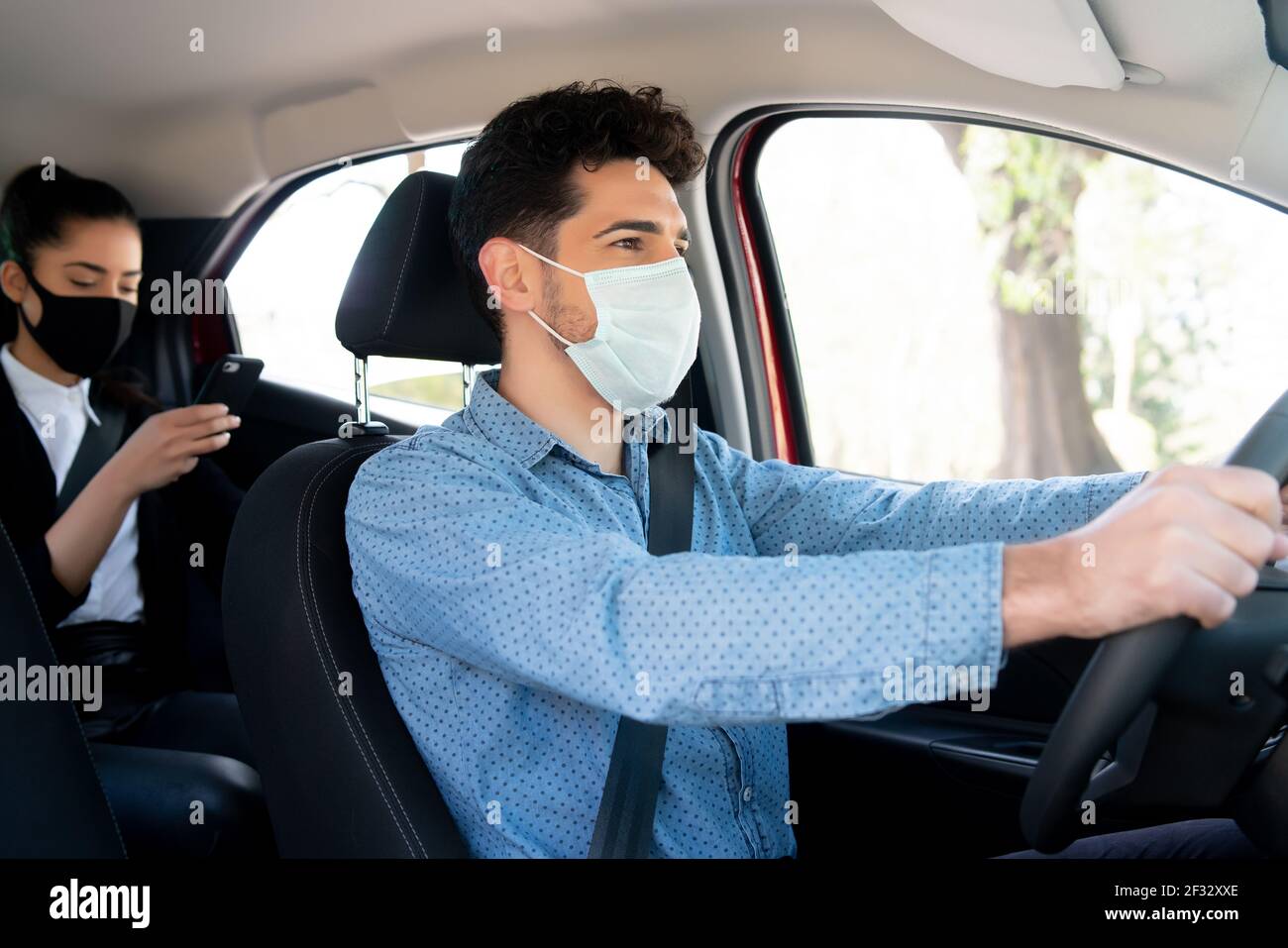 Taxi driver with passenger at back seat Stock Photo - Alamy