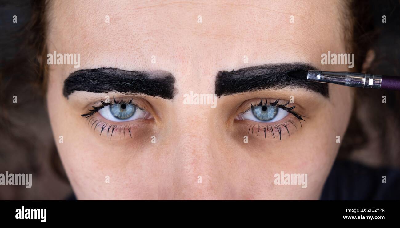 eyebrow dyeing,woman tints and corrects the eyebrow Stock Photo - Alamy
