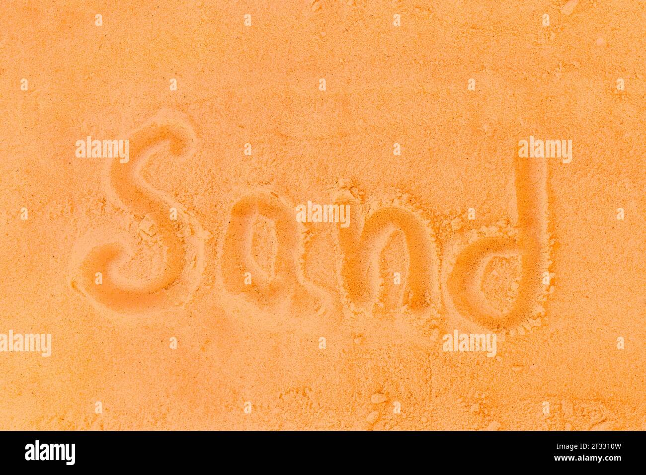 The word sand is written on a orange beach sand background. Sign or ...