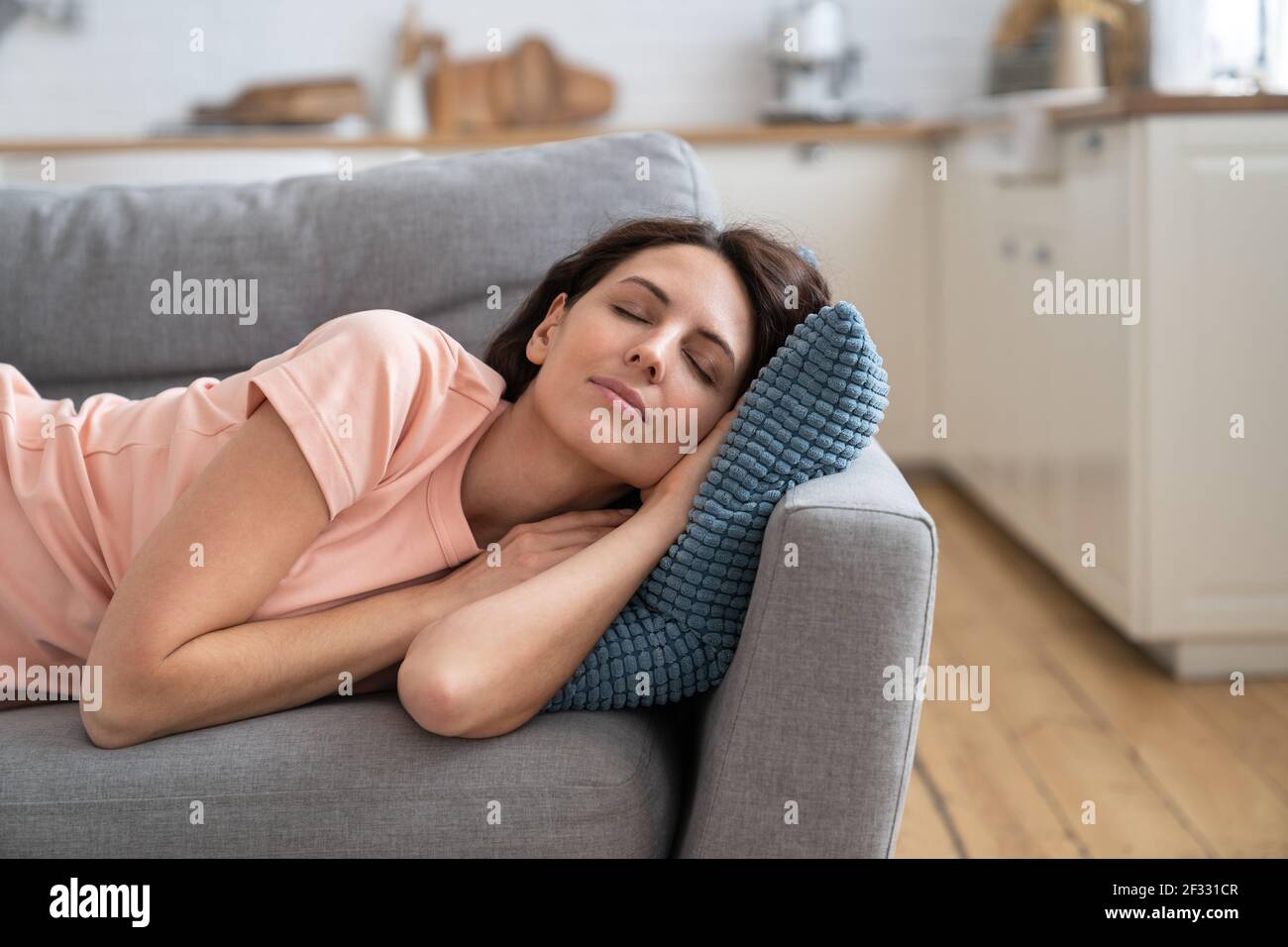 Young woman lying on on pillow on couch, resting, relaxing, sleeping after completing house ...