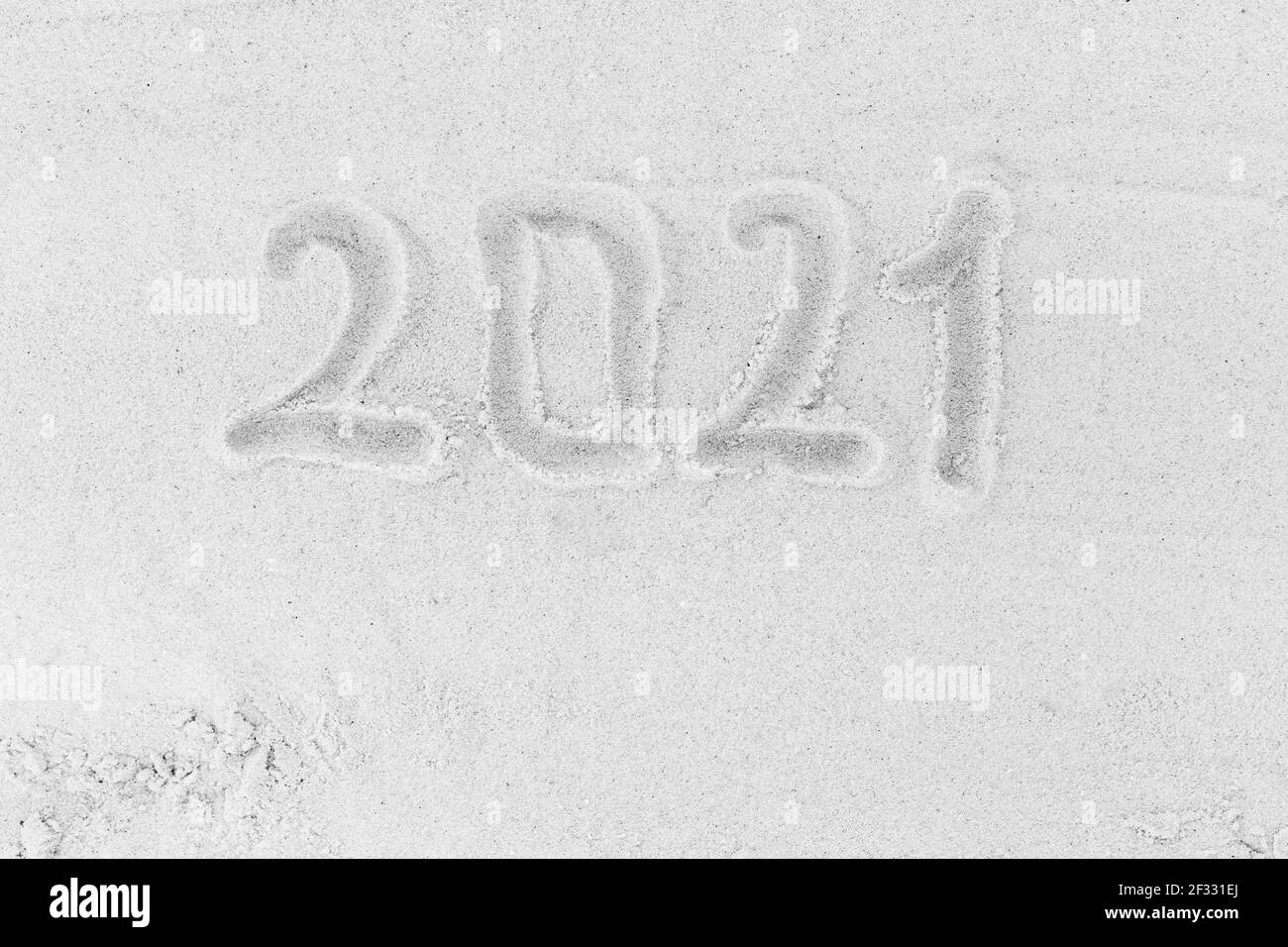 2021 word or symbol written on white beach sand background close-up ...