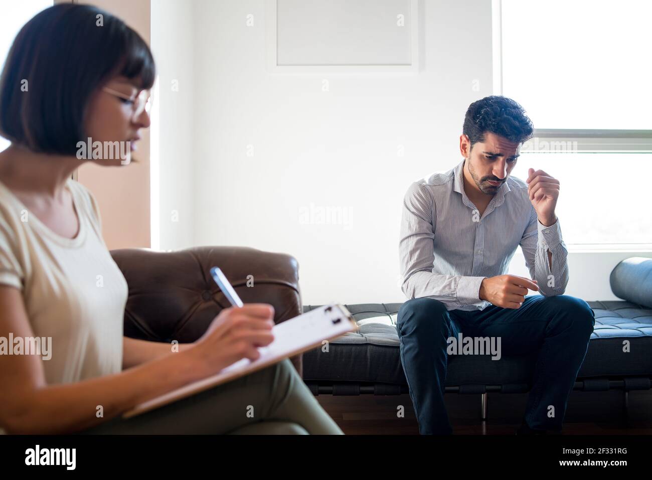 Psychologist taking notes during therapy session Stock Photo - Alamy