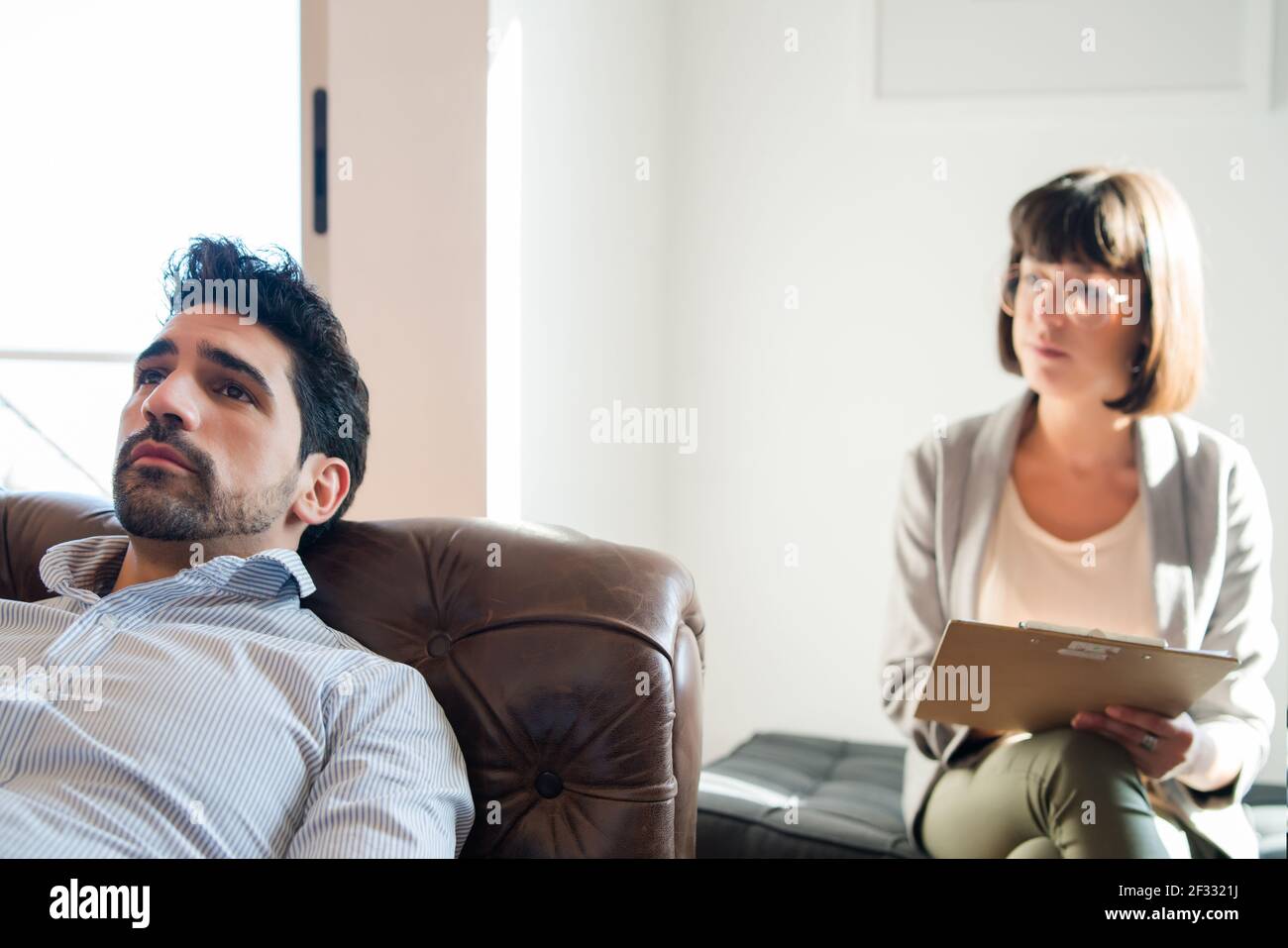 Psychologist taking notes during therapy session Stock Photo - Alamy