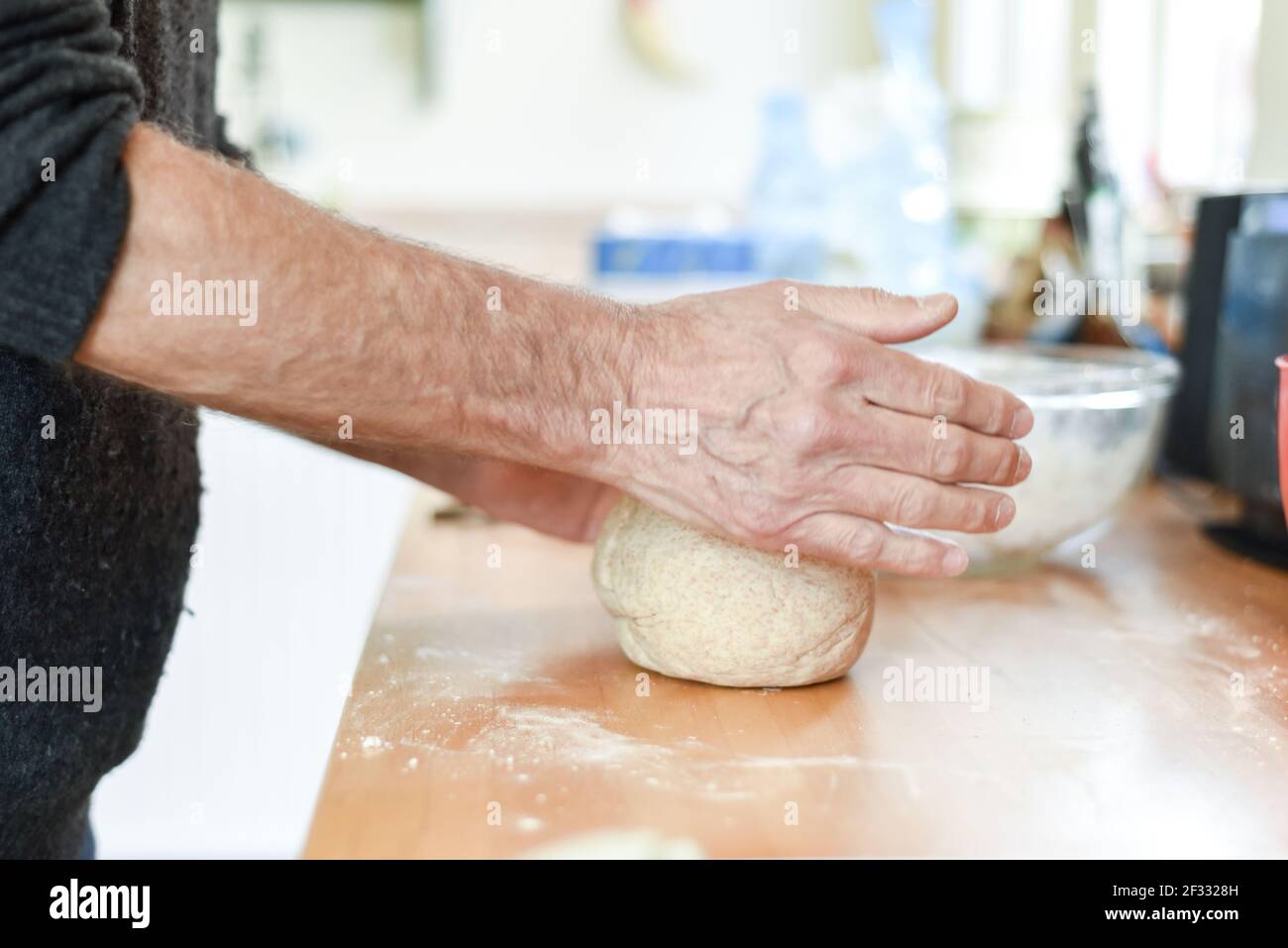 Person making bread in a home kitchen adding ingredients to make the ...