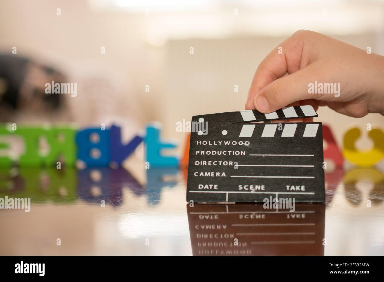 Hand holding movie clapper on a dark background Stock Photo - Alamy