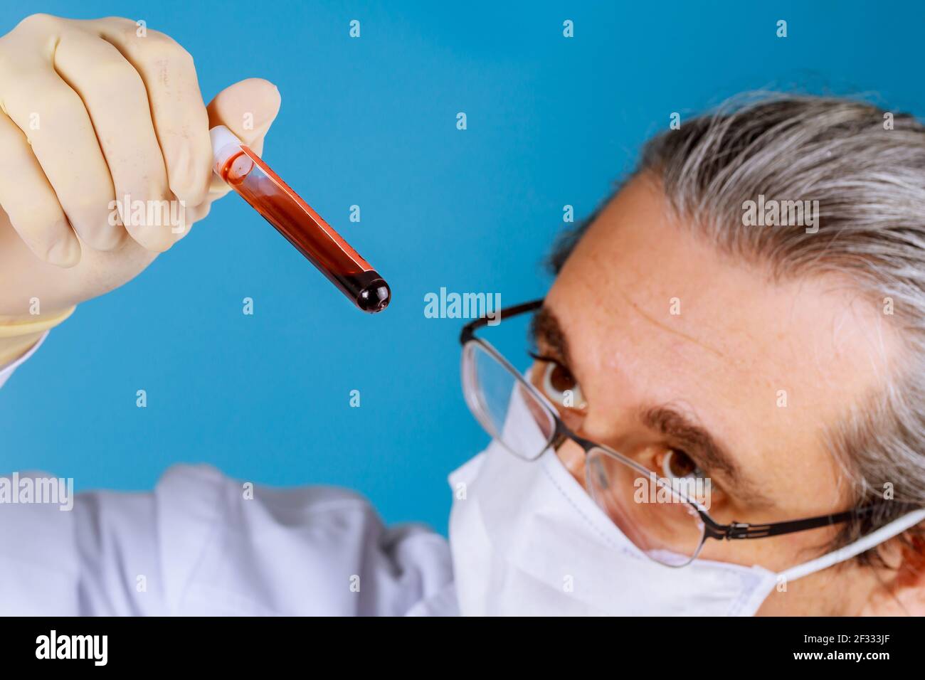 Doctor hand with blood test tubes in research lab Stock Photo - Alamy