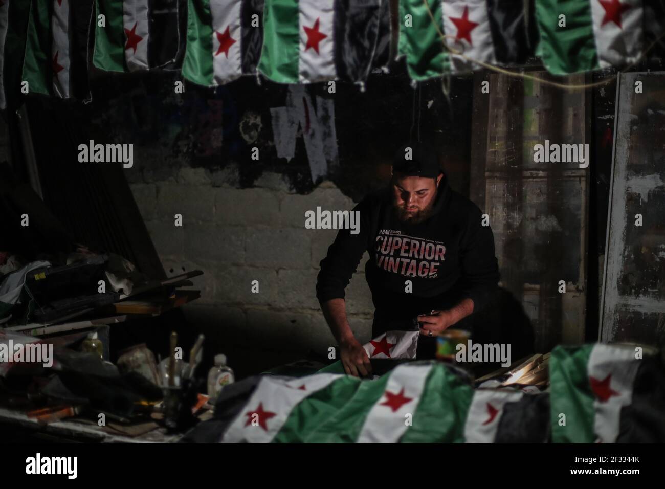 Binnish, Syria. 14th Mar, 2021. Syrian activist prepare flags and ...