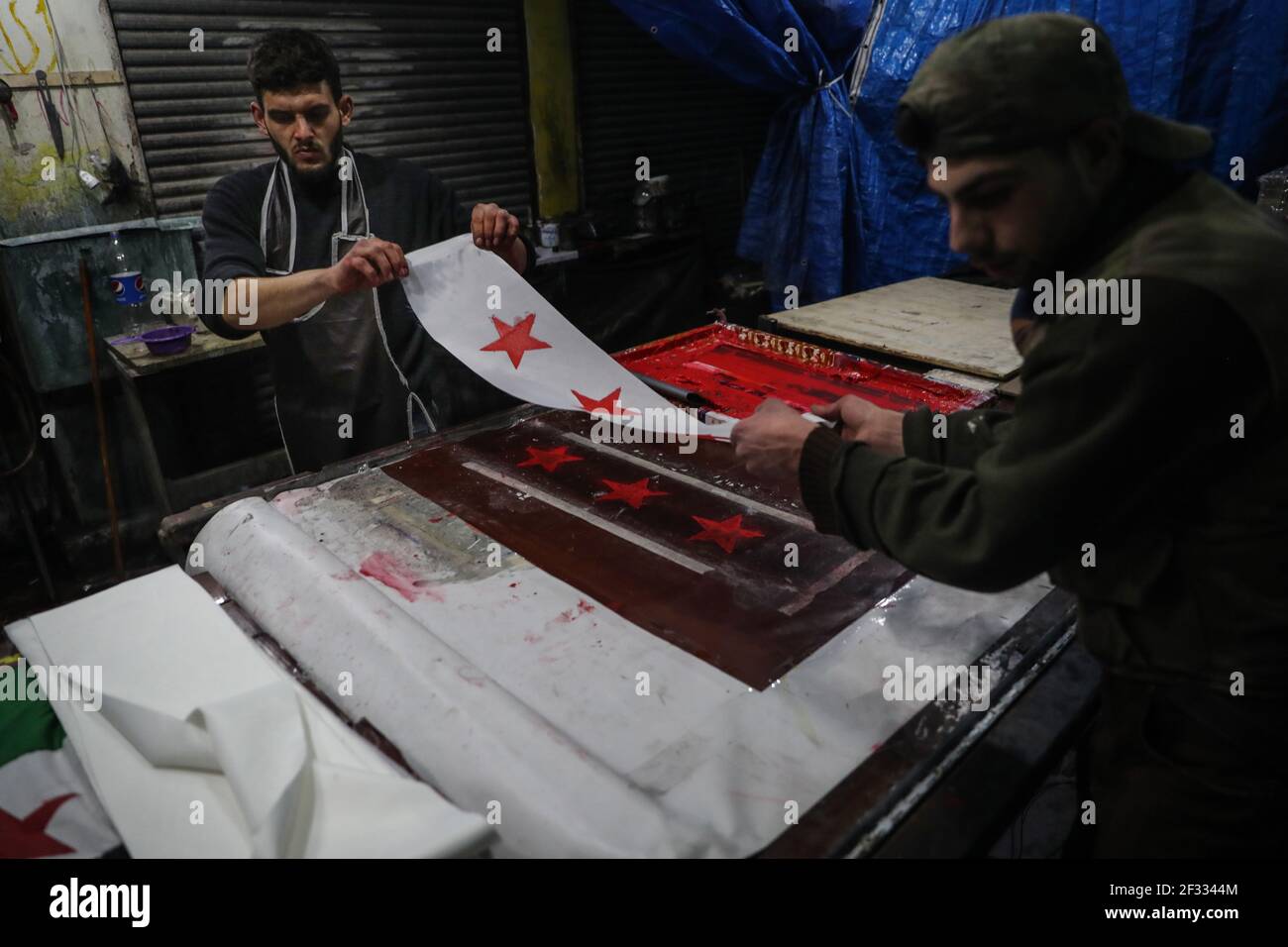 Binnish, Syria. 14th Mar, 2021. Syrian activist prepare flags and ...