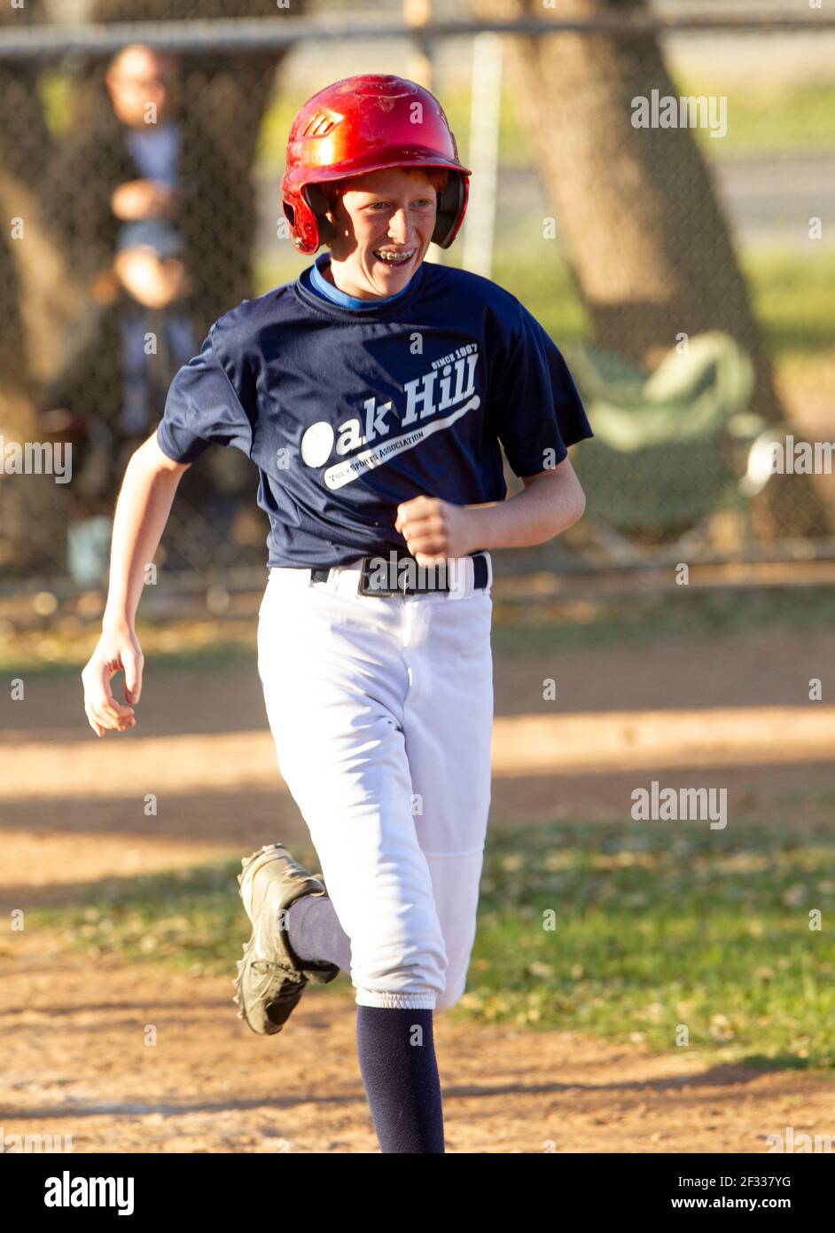 A red-headed teenage baseball player plays baseball in a youth league ...