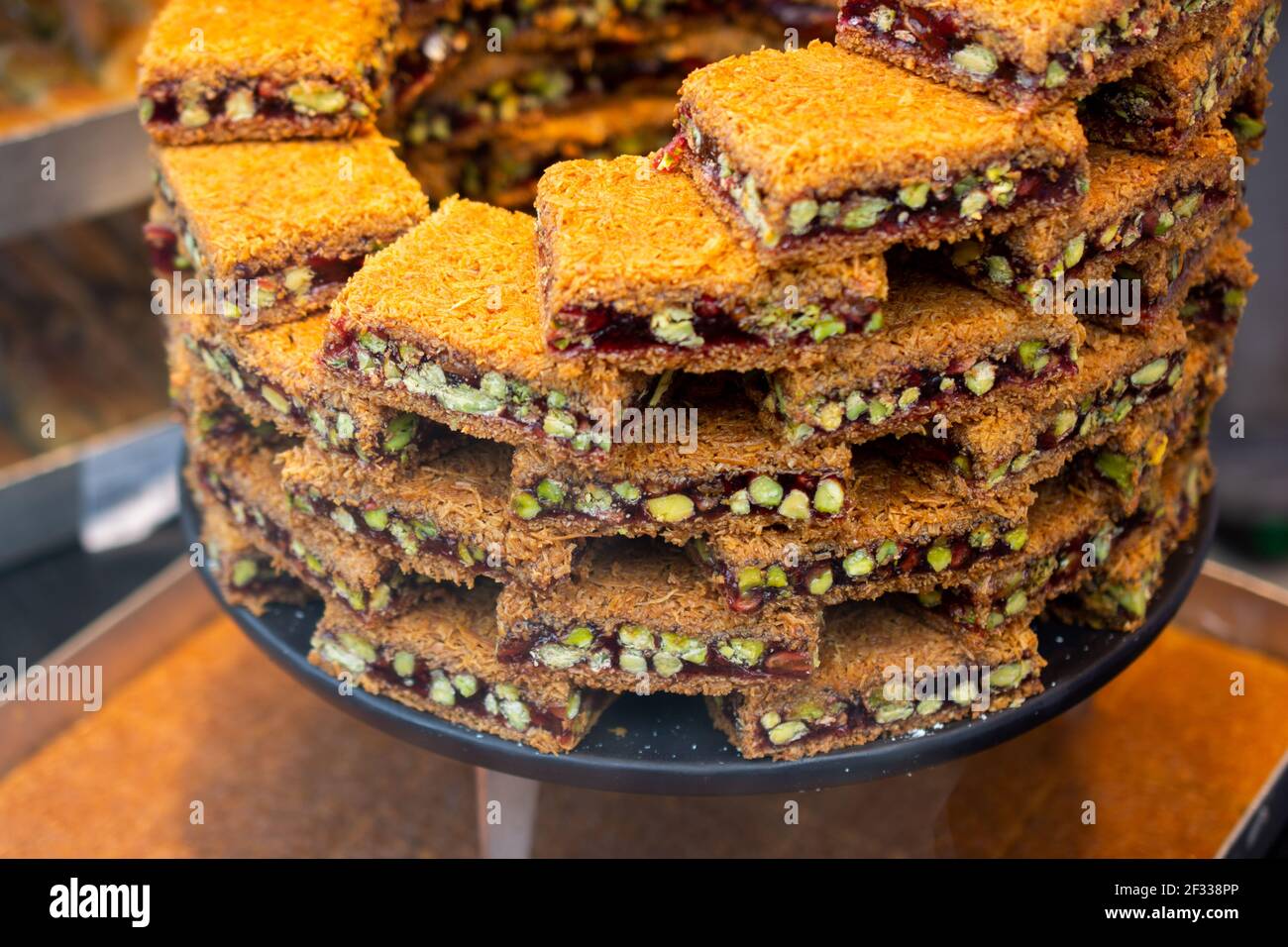 Turkish traditional dessert Kadayif baked in syrup served with nut ...