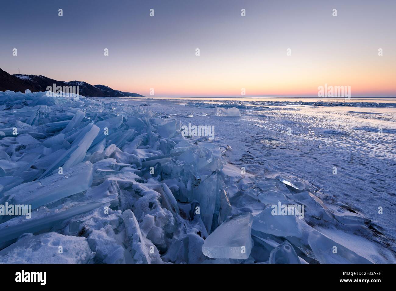 Lake Baikal in Siberia at sunset, a pile of beautiful ice hummocks with ...