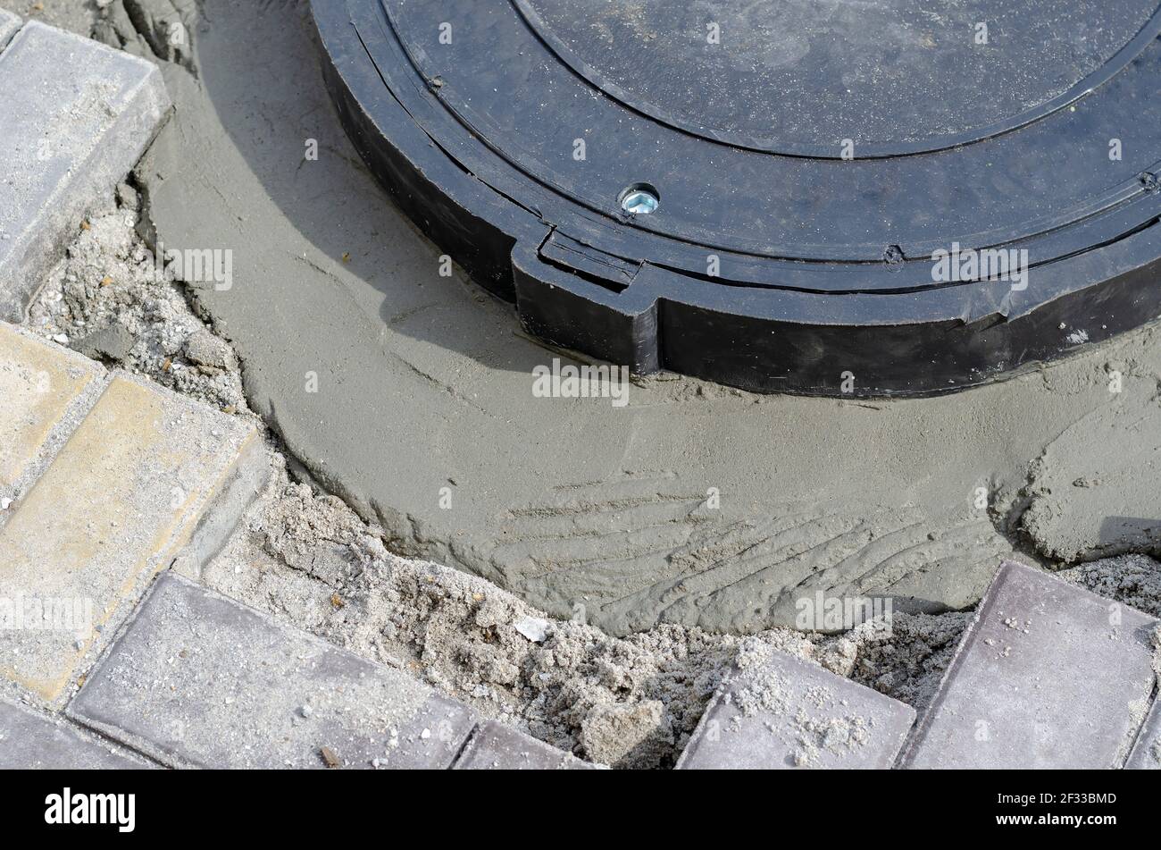 Installation of a new sewer hatch. Fragment of a black plastic hatch in ...