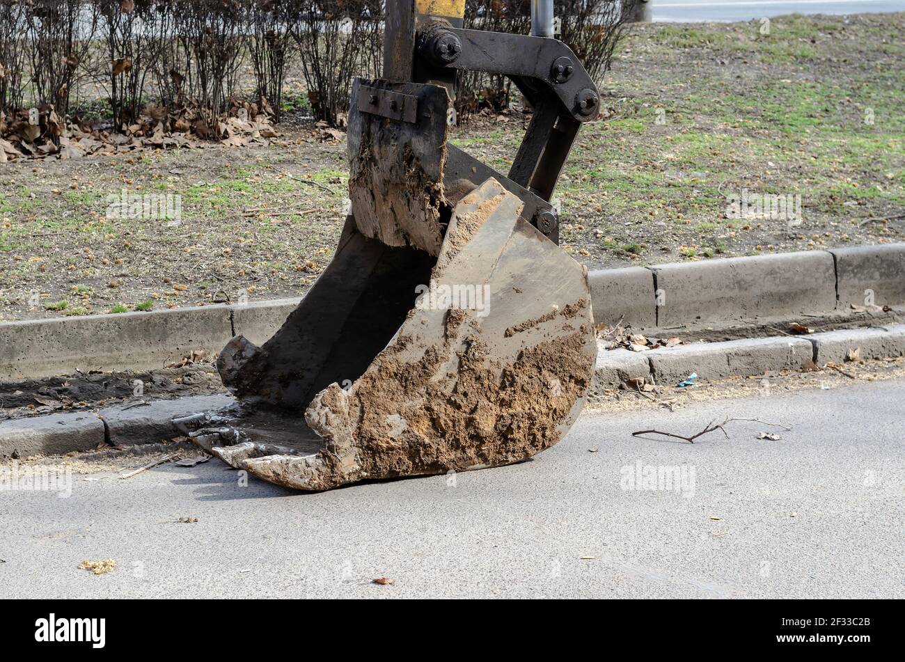 Repair and restoration work on a city street. Dirty bucket excavator ...