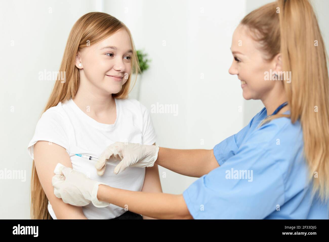 woman doctor giving a child a girl an injection in the arm covid Stock ...