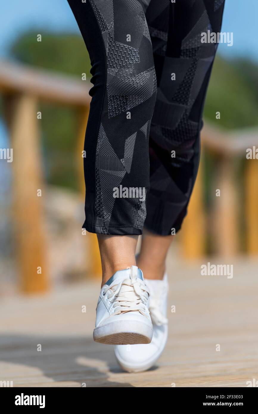 Running woman's legs with running gear on an out of focus background ...