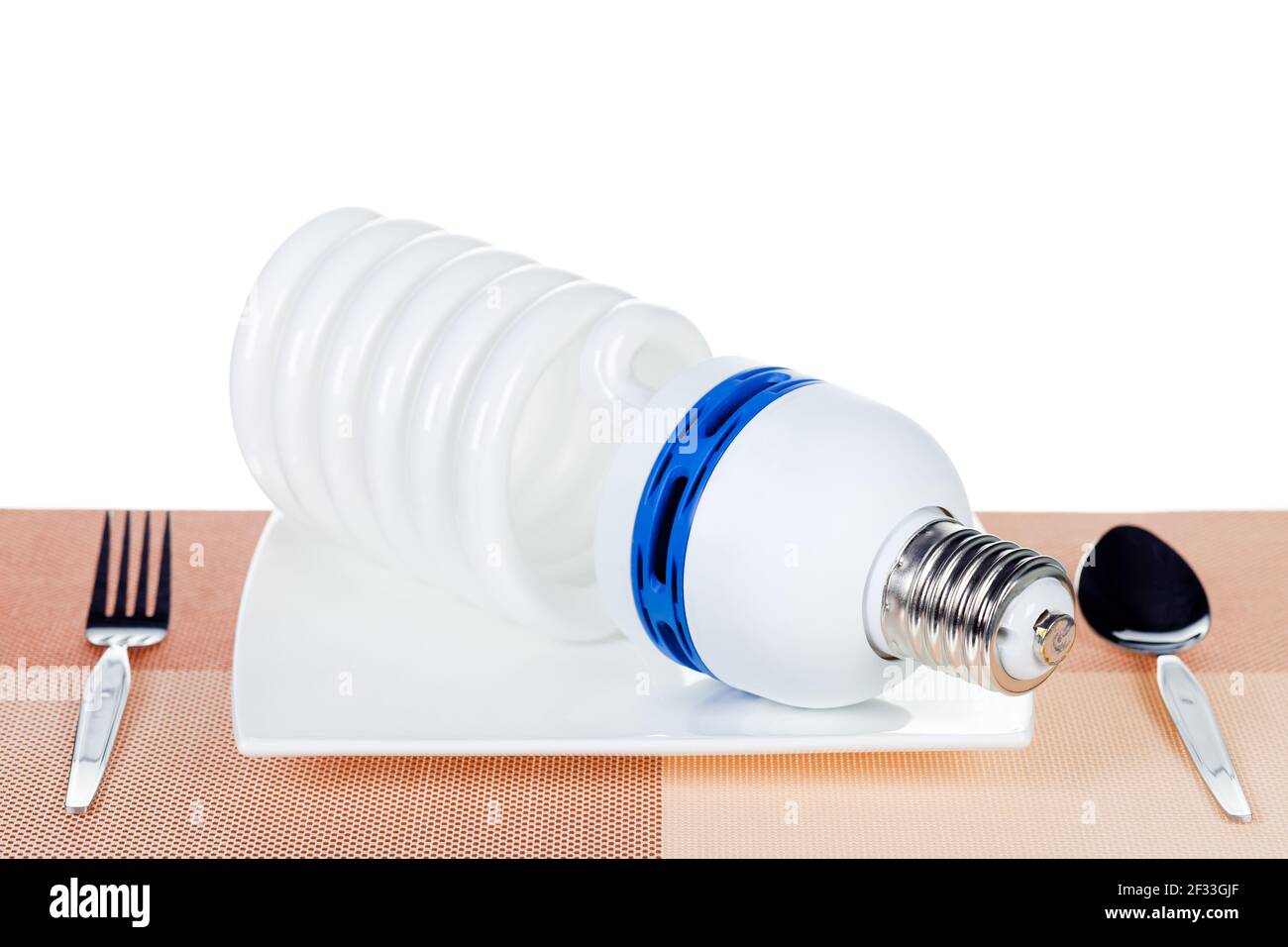 Light bulb on plate, steel fork and spoon, Isolated on white background ...