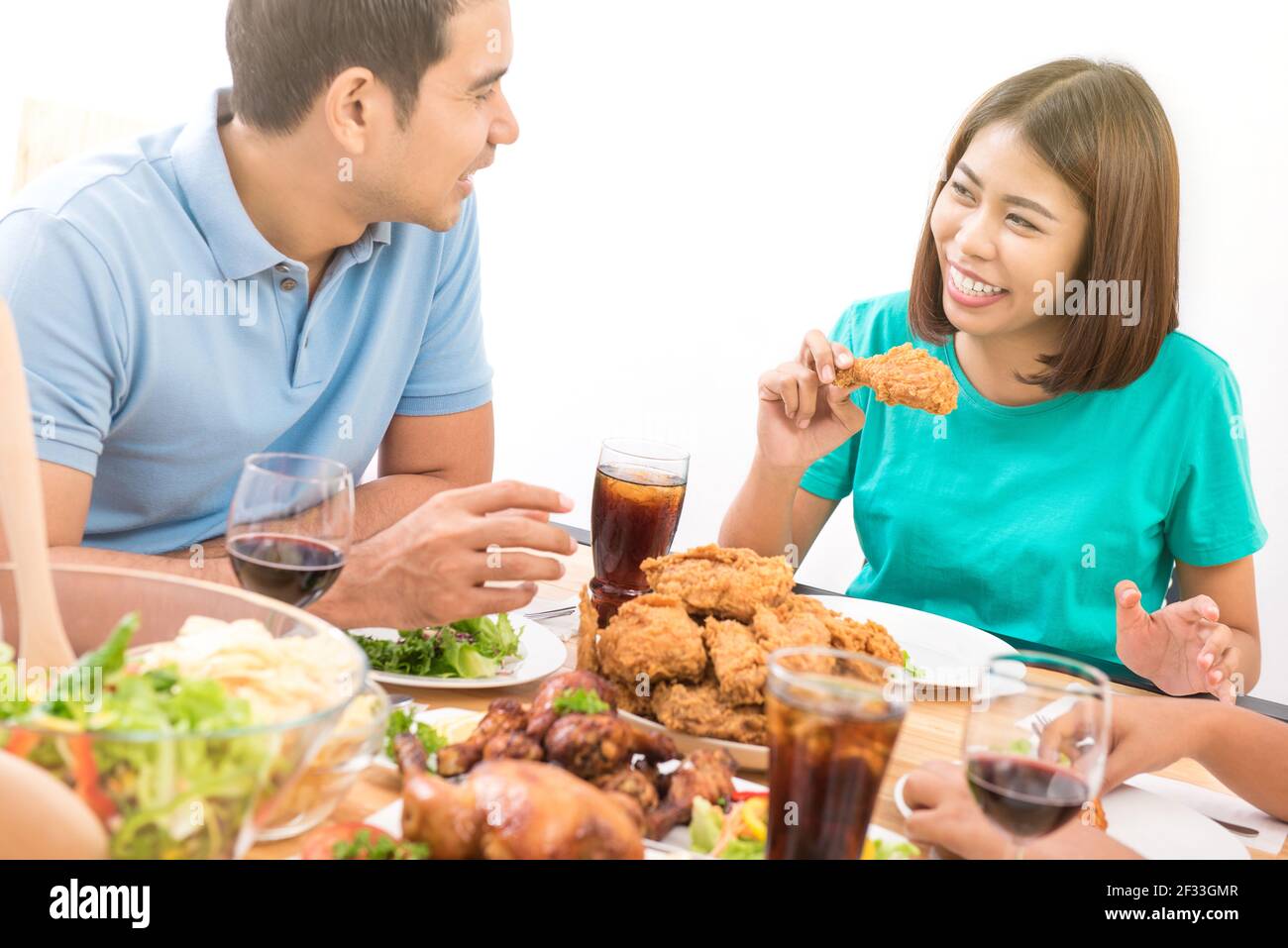 Happy Asian couple smiling to each other while eating dinner Stock ...
