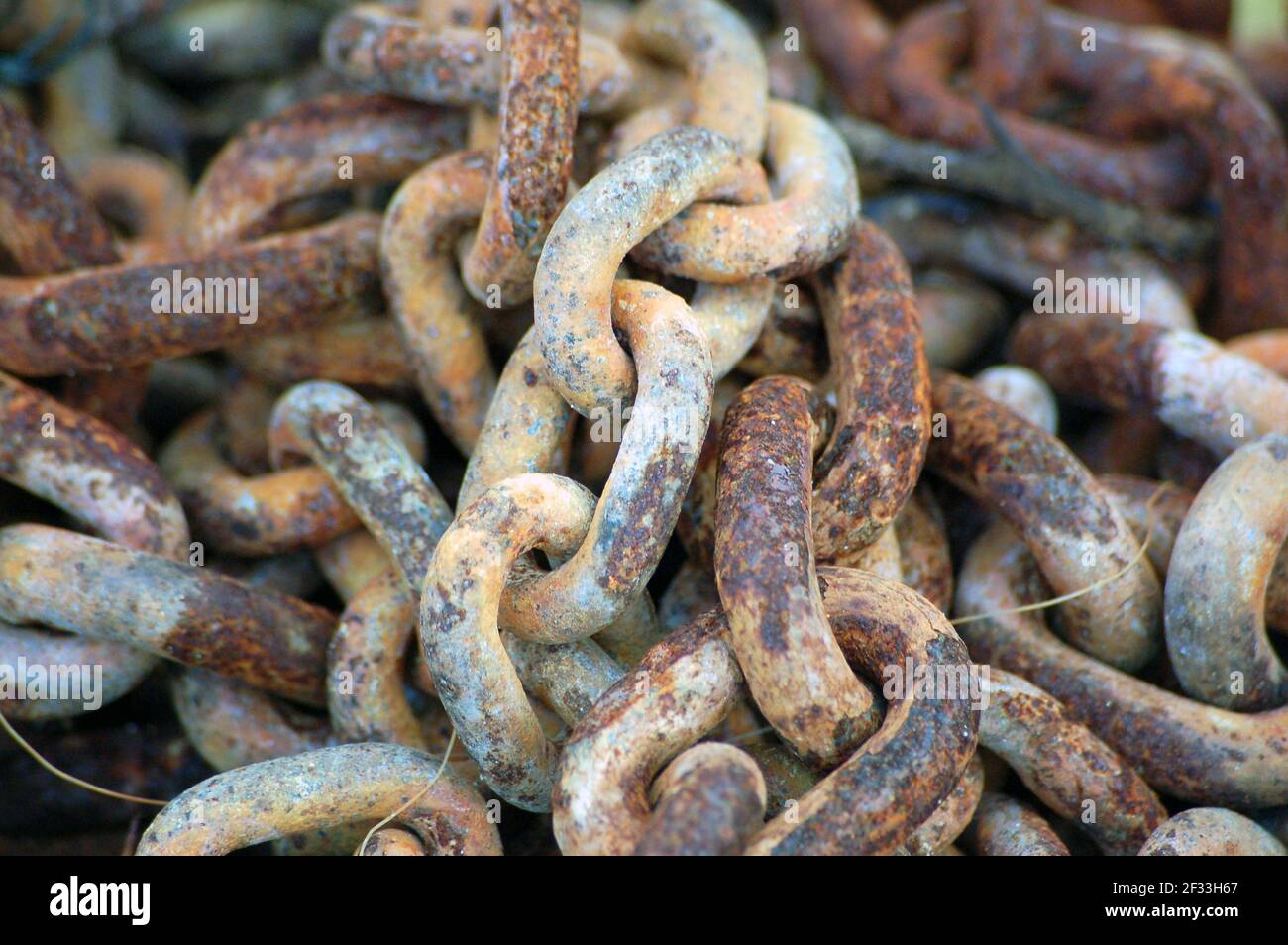 A heap of rusty chain links suitable for use as background or wallpaper ...
