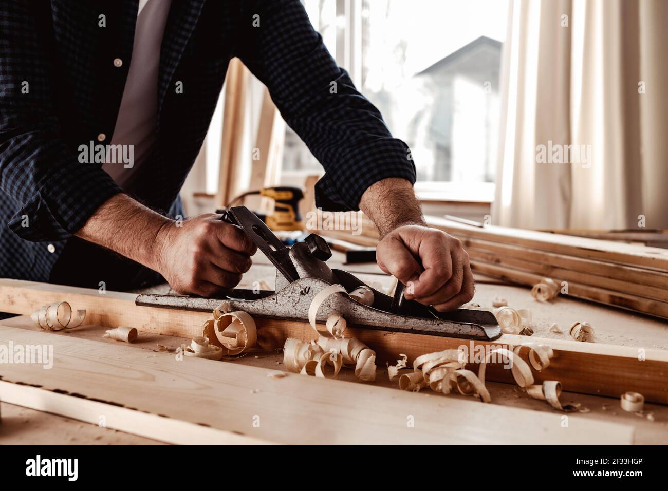 Carpenter's hands planing a plank of wood with a hand plane Stock Photo ...
